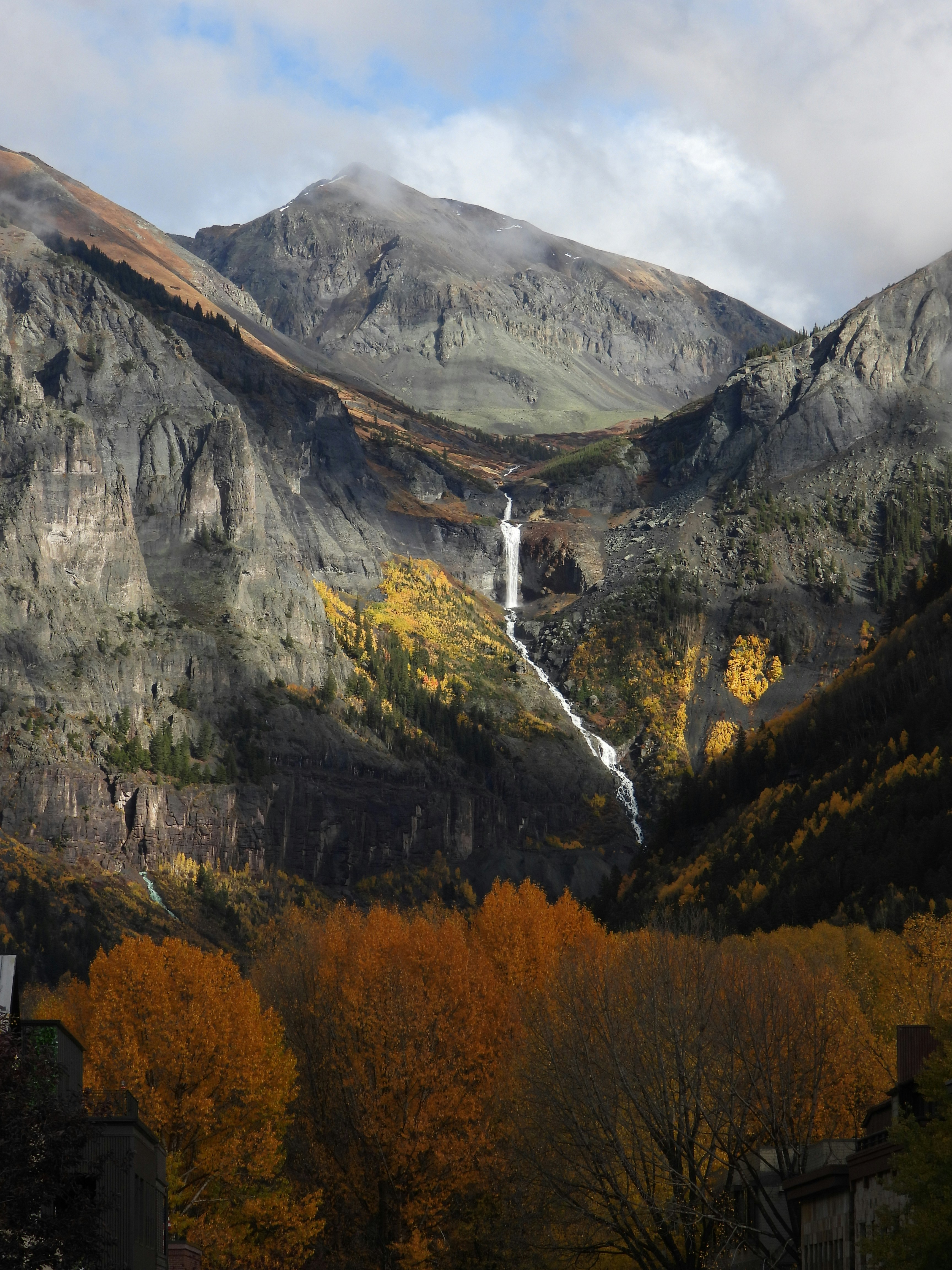 Golden Cascade: Fall Colors Framing a Mountain Waterfall