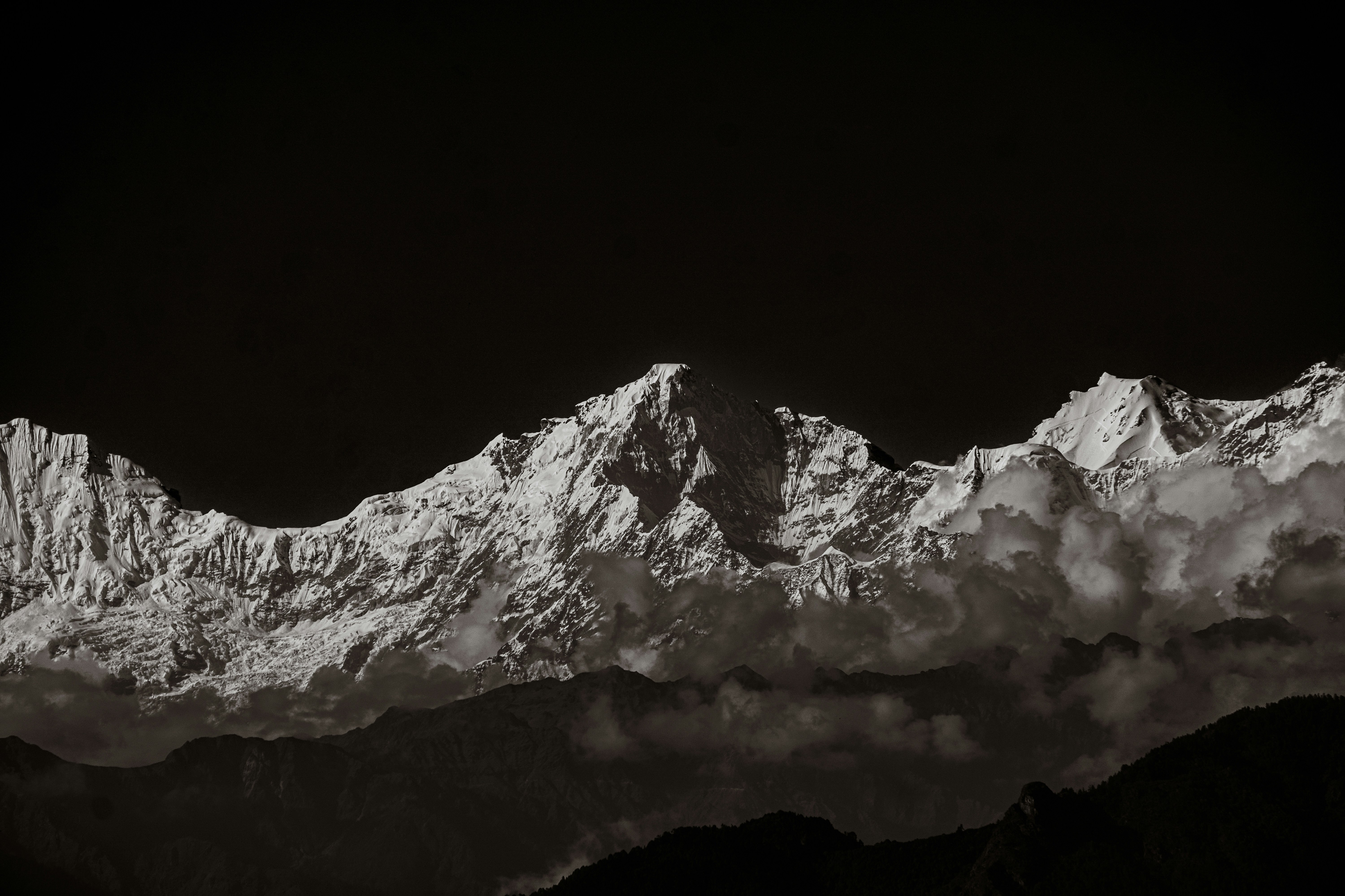 Snow-covered mountain range under a dark sky