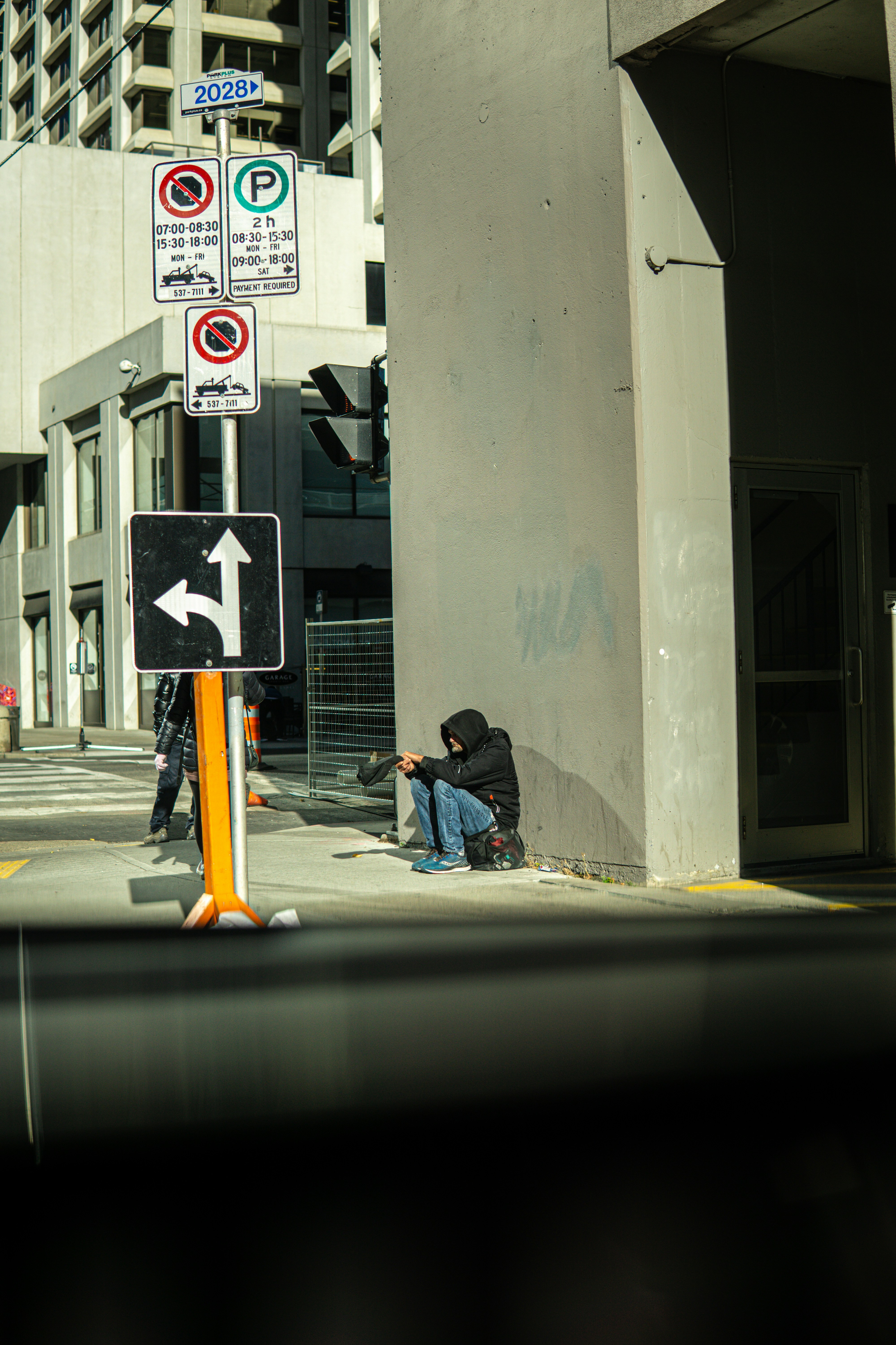 Quiet Solitude at the Edge of the City: A Lone Figure Beneath Concrete Pillars