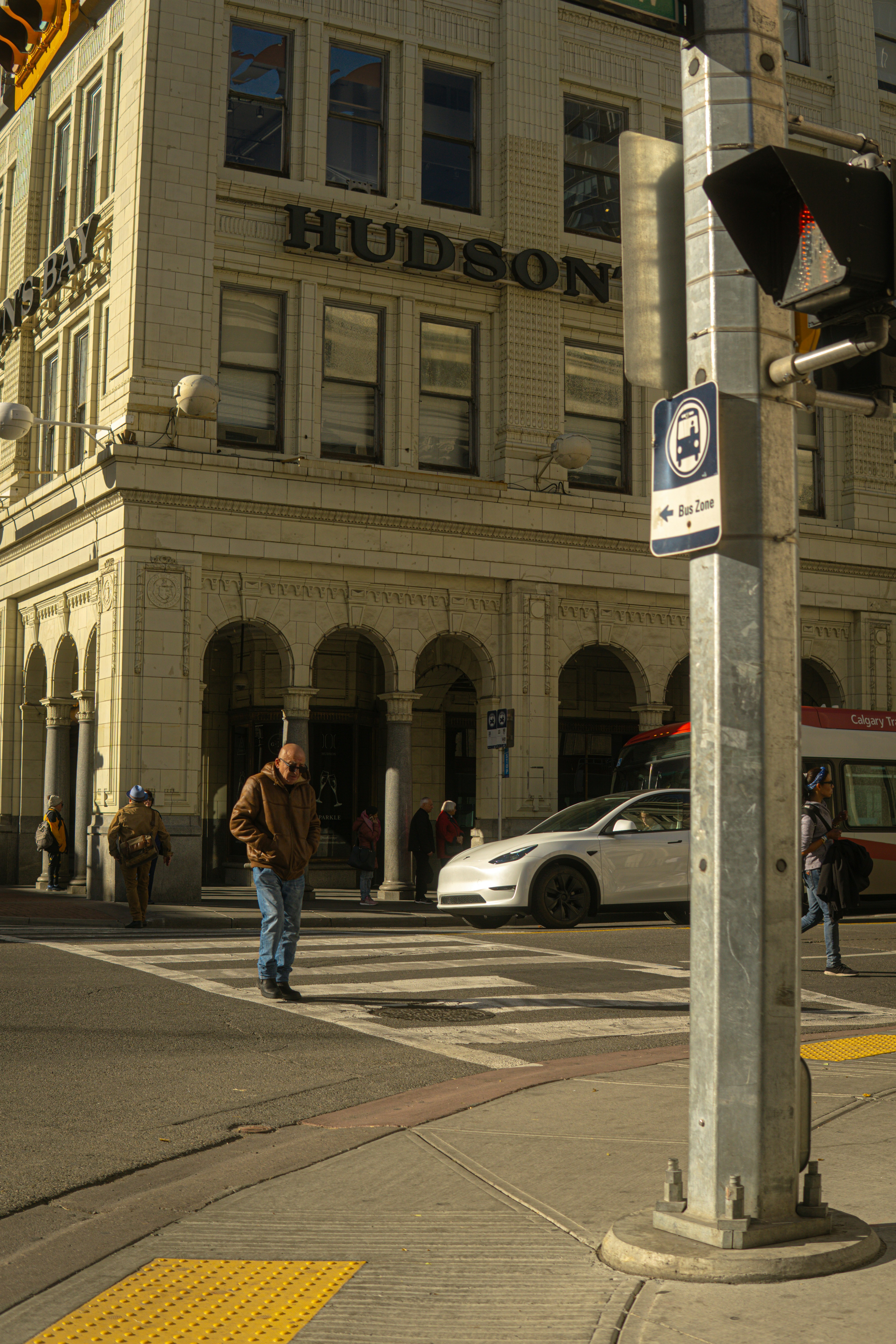 Brown-Jacket Moment Beneath Hudson's Façade