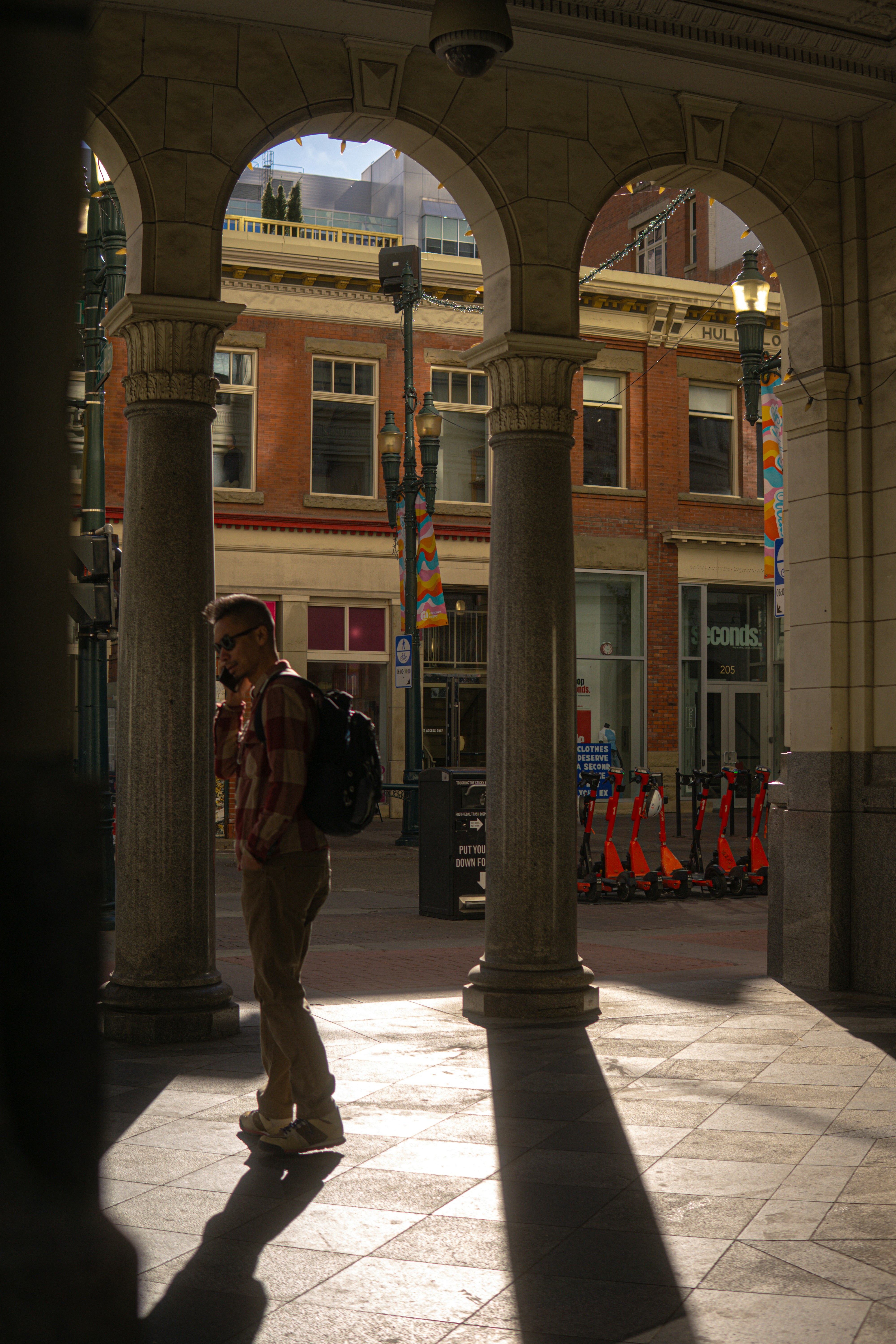 Traveler in Shadow Beneath City Arches