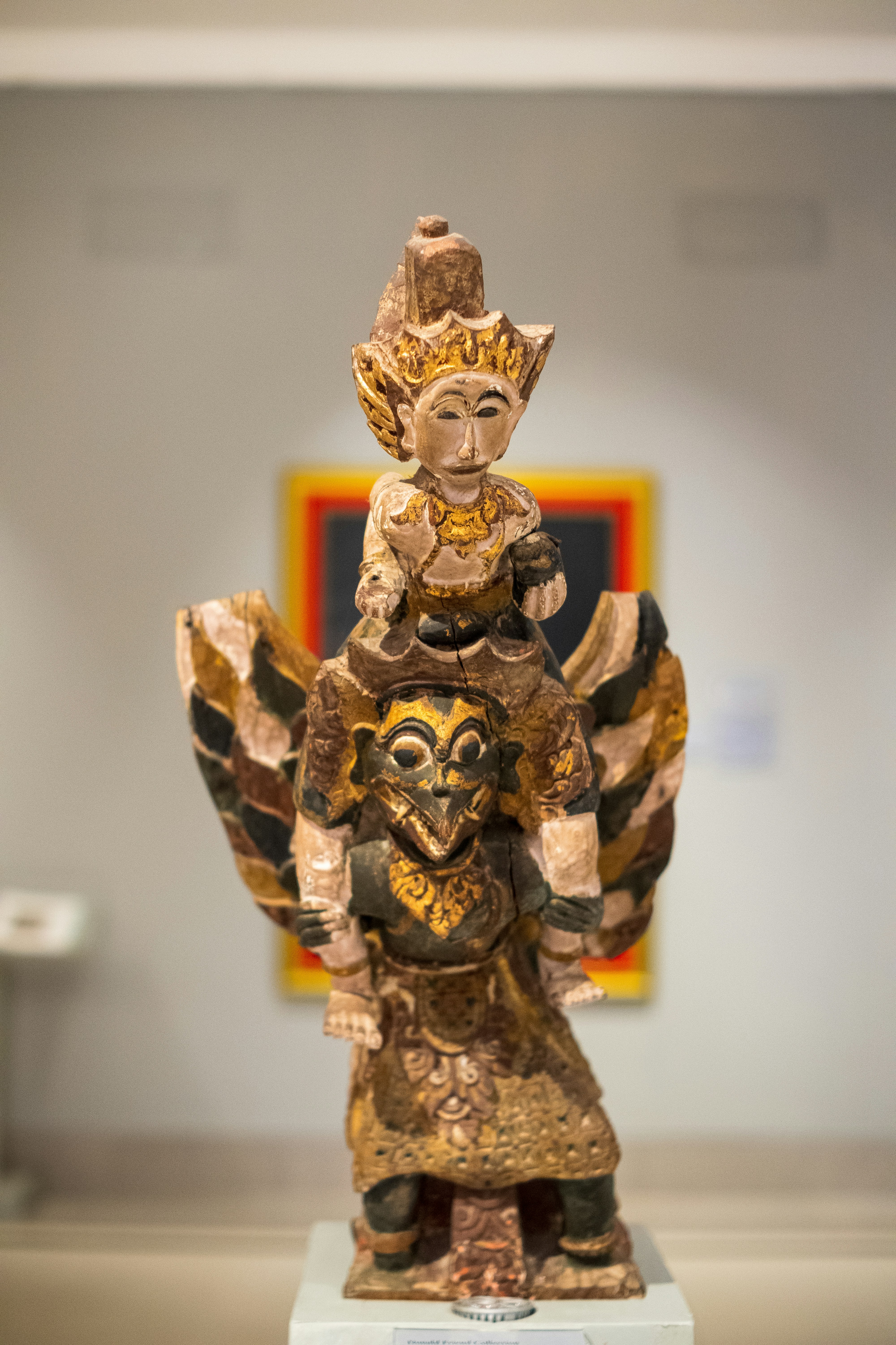 Winged Guardian on a Carved Throne: A Wooden Sculpture in Soft Gallery Light