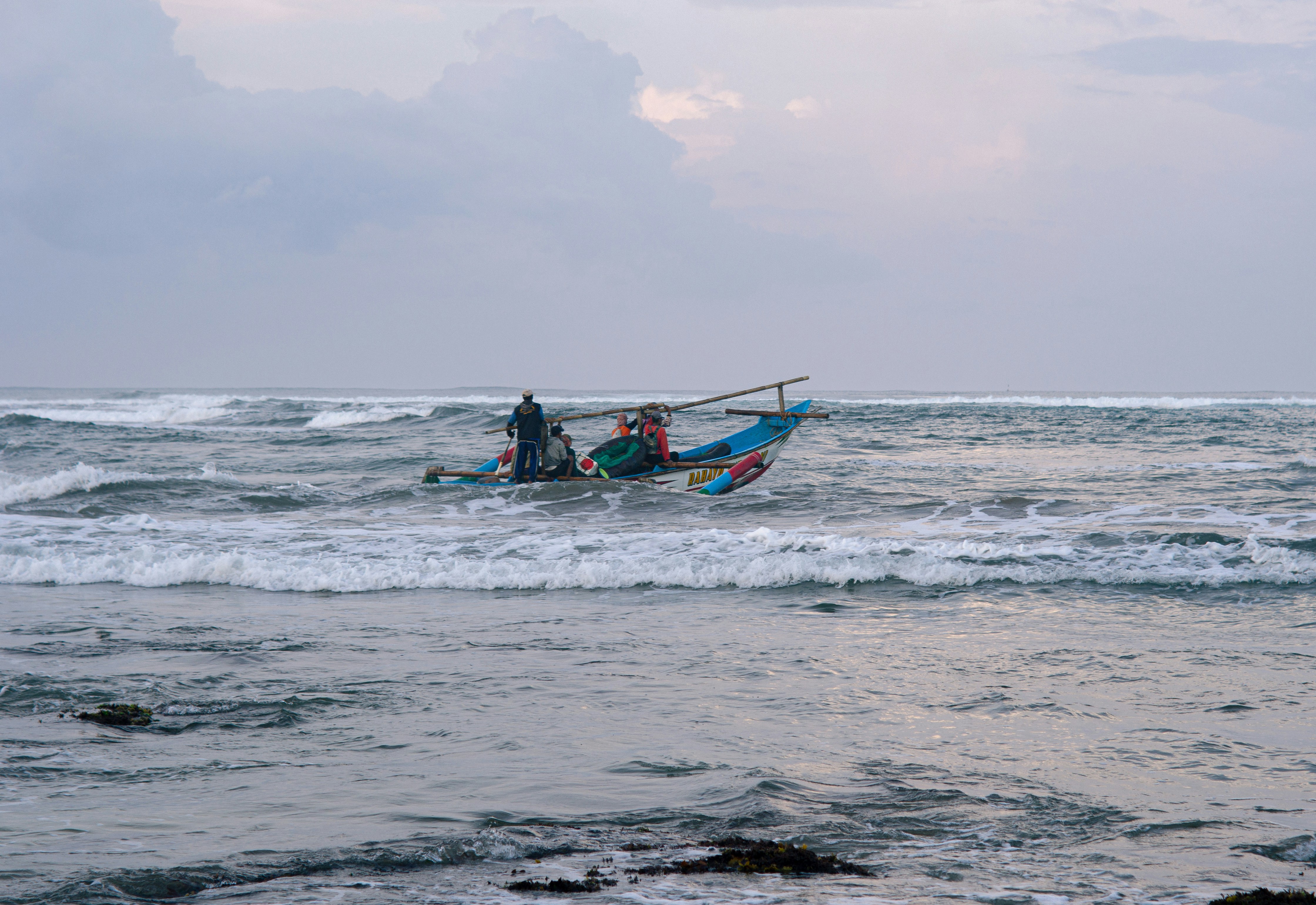 OLYMPUS DIGITAL CAMERA | Two people in a small boat on choppy ocean waves