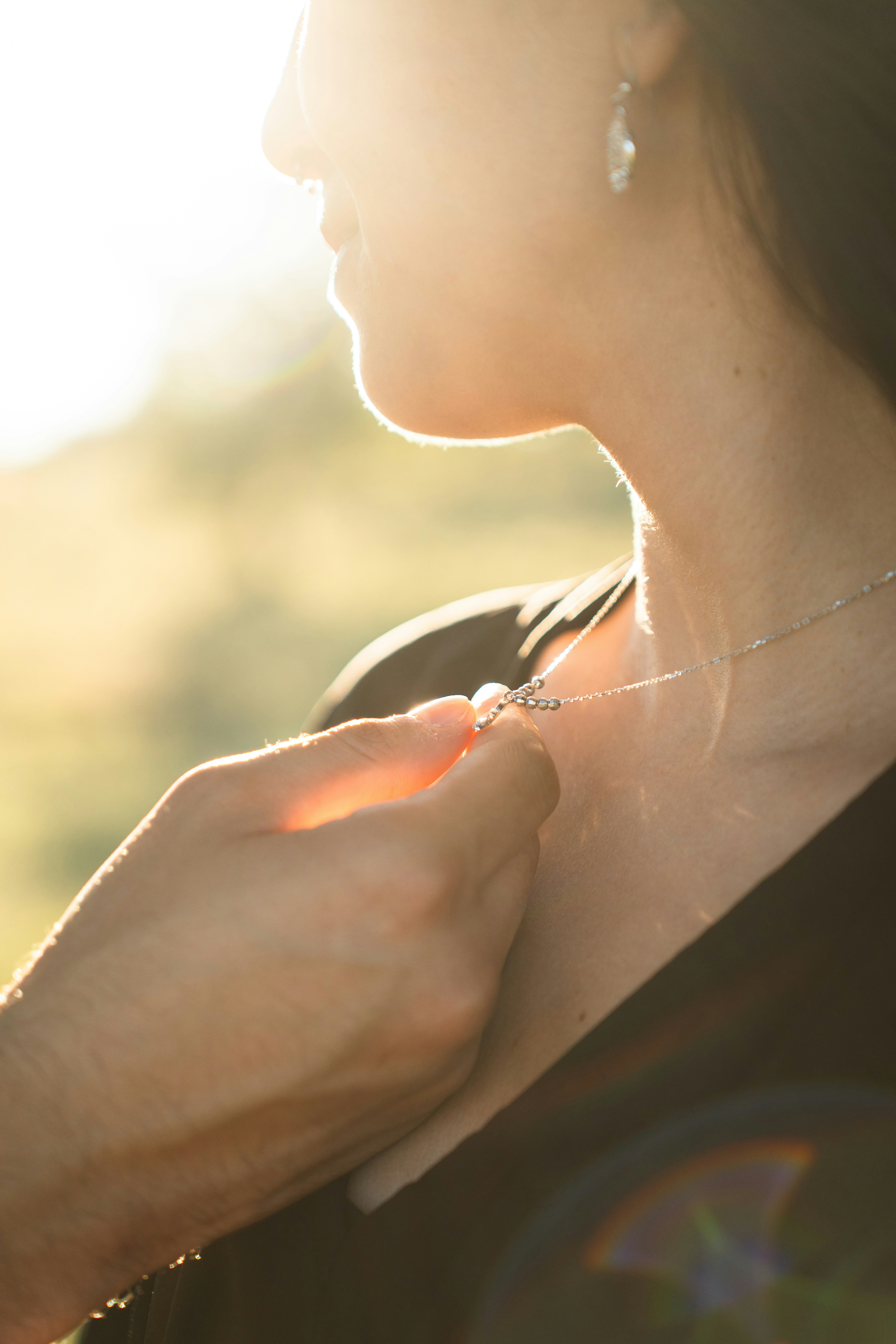 Man fastening a necklace on a woman's neck