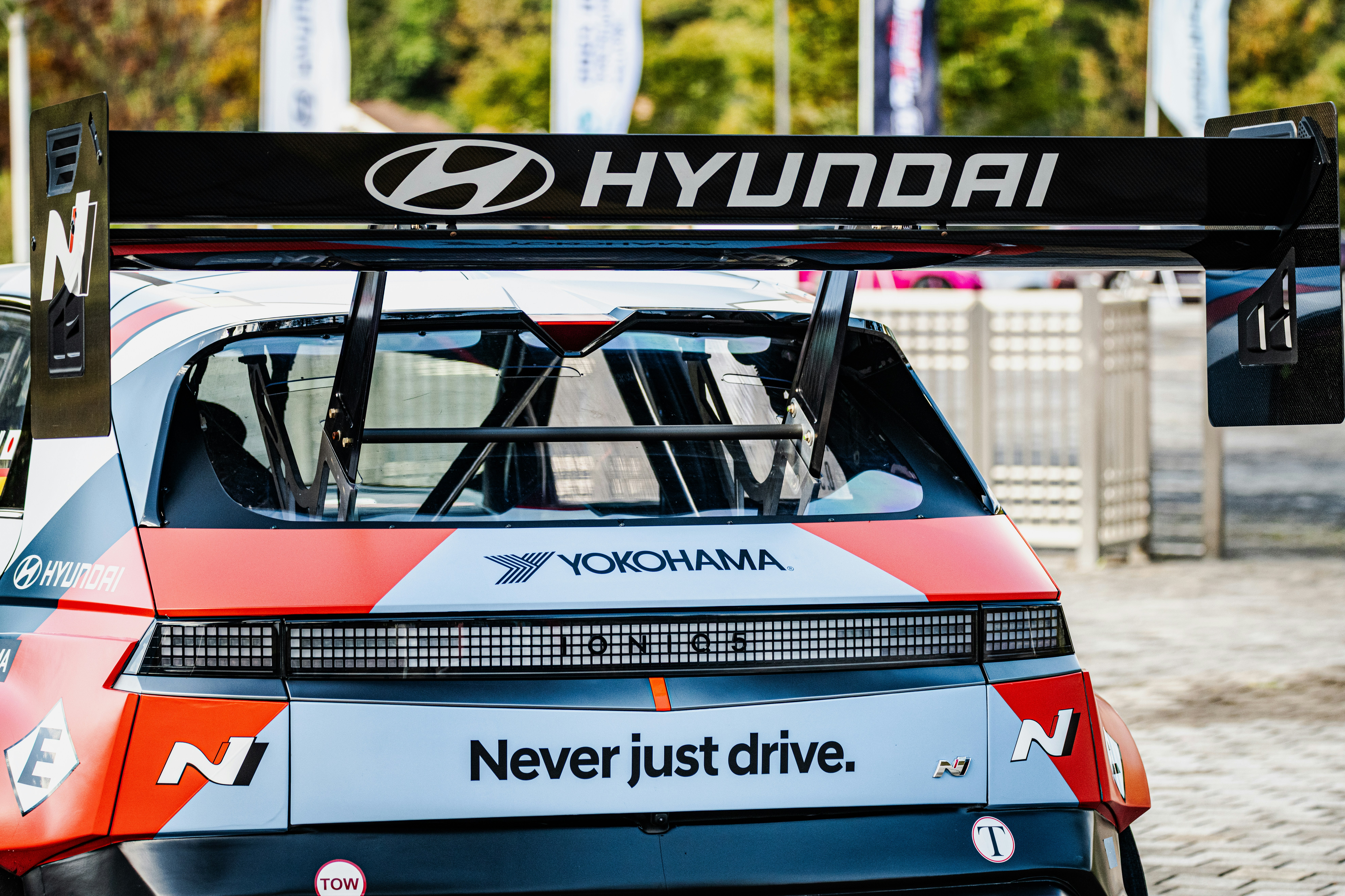 Rear view of a Hyundai racing car showcasing its aerodynamic design and sponsor logos, emphasizing performance and branding.