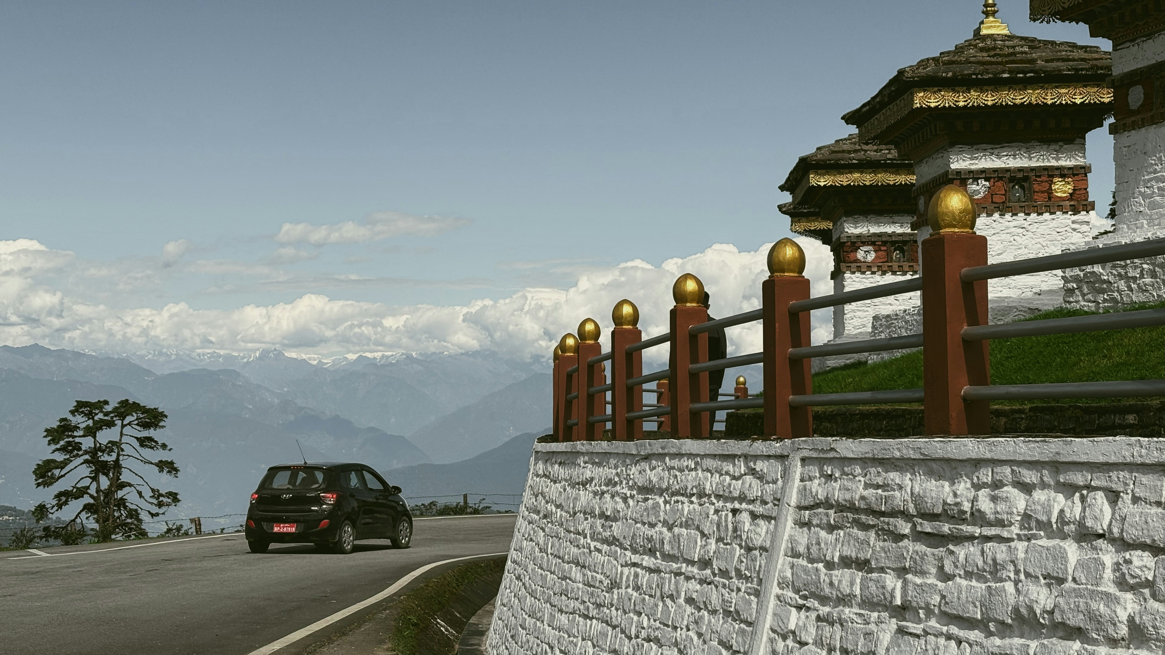 Ridge Road Reverie: Black SUV on a Mountain Pass by Stone Balcony and Golden Pavilion