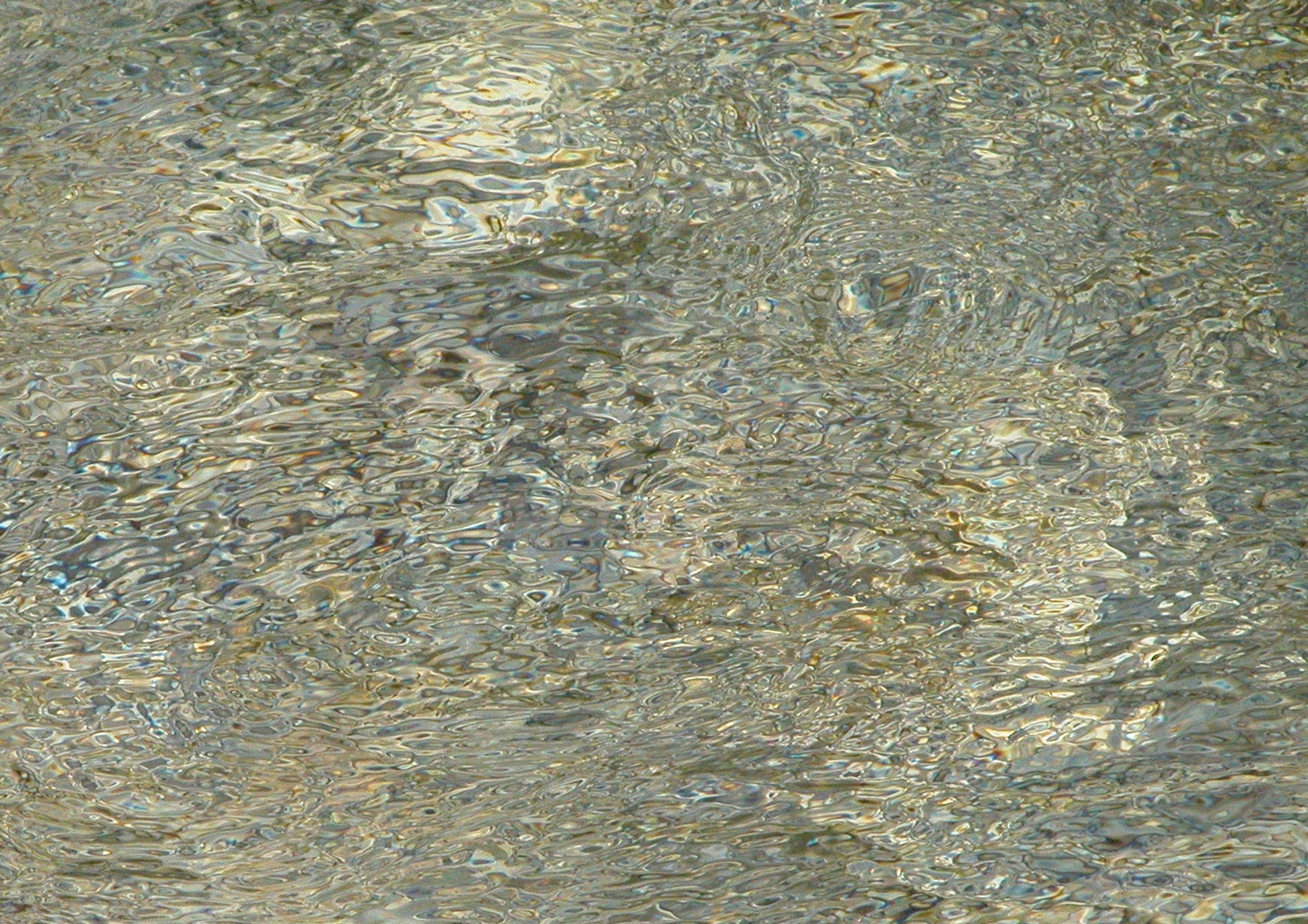 Reflets | Rippling water surface with sunlight reflections.