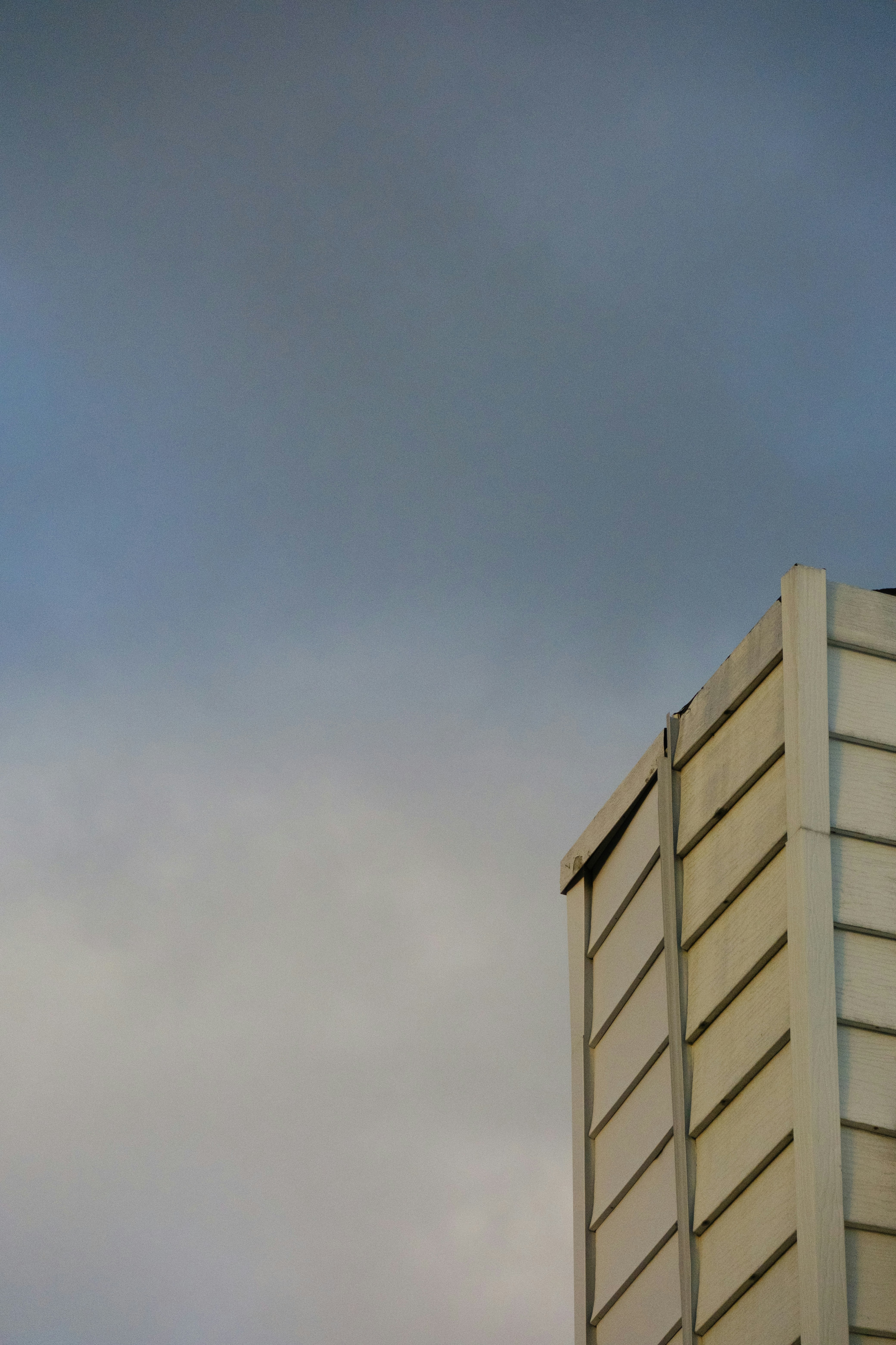 top of chimney with blue sky background | Corner of a building against a cloudy sky