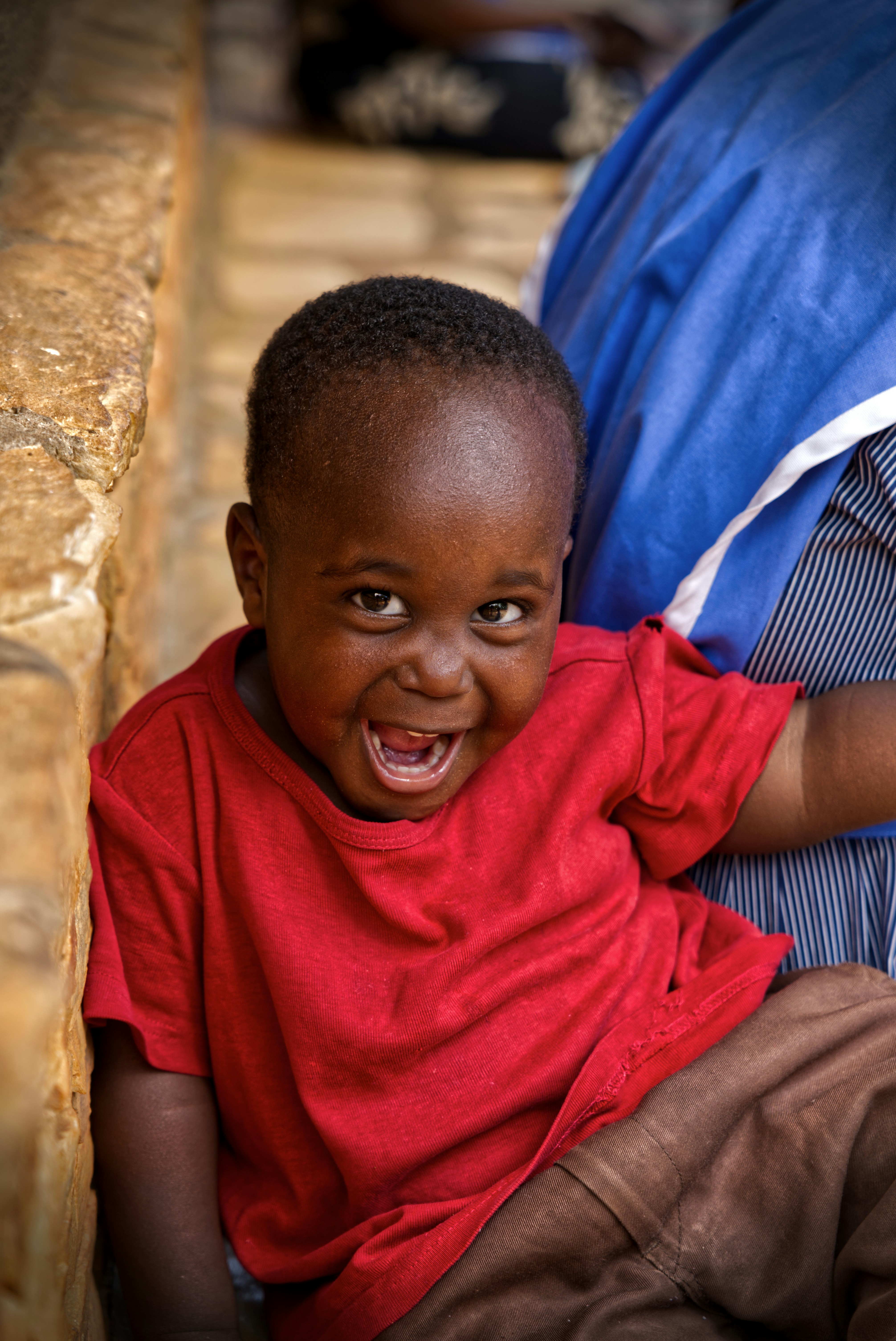 Little man smiling | A happy young boy in a red shirt laughs.