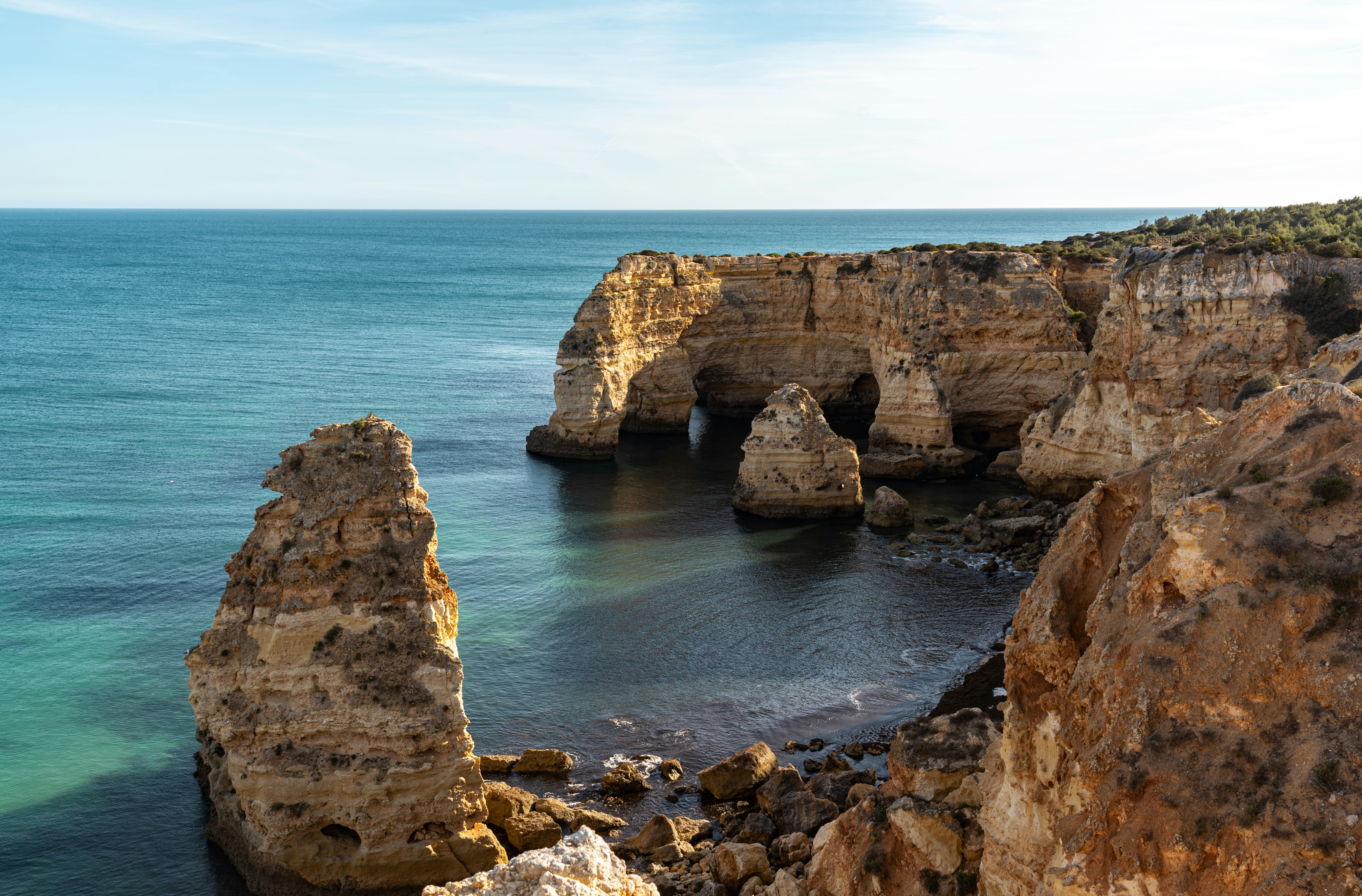Rocky coastline with arches and clear blue ocean