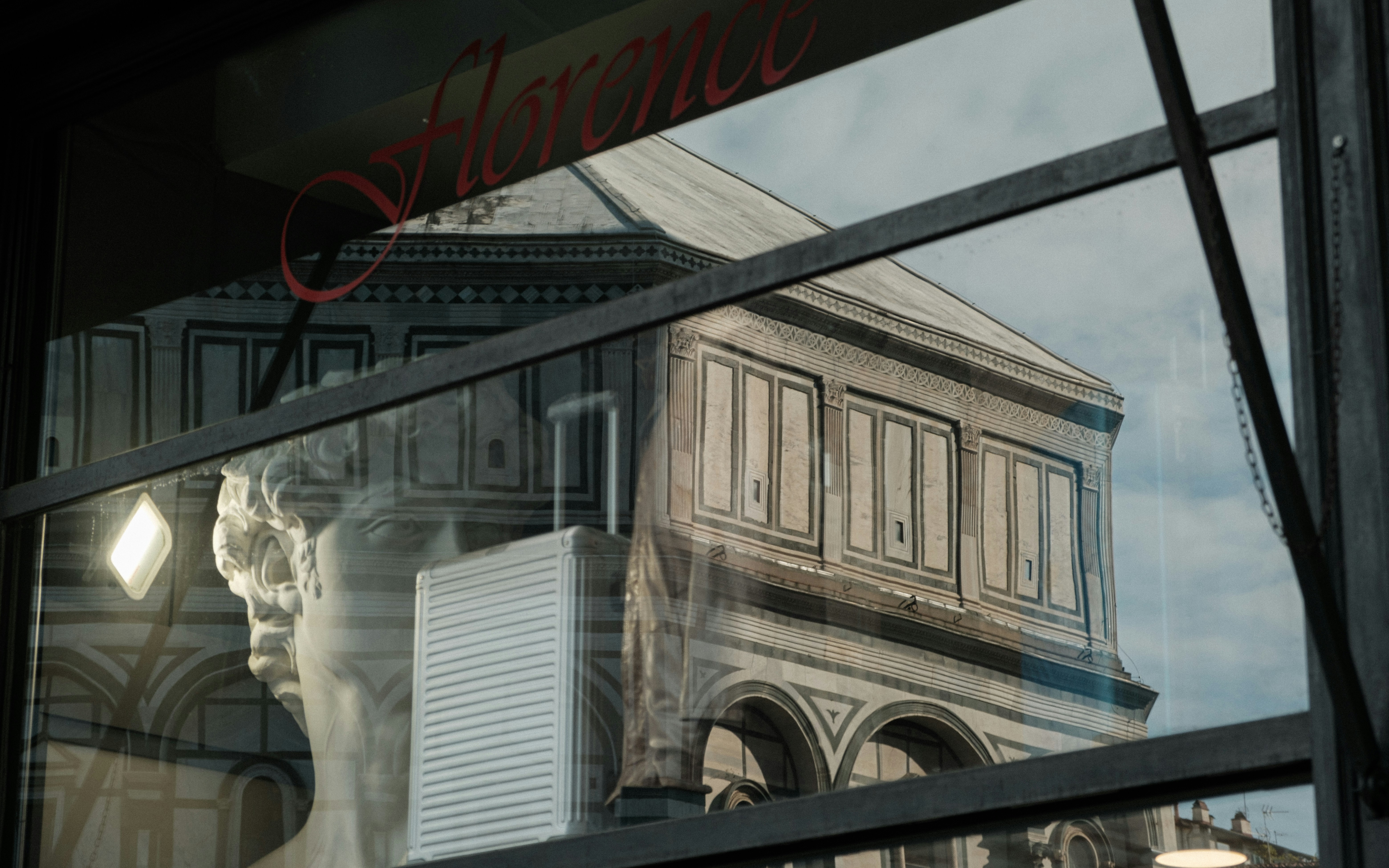 Reflection of classical architecture and sculpture in window