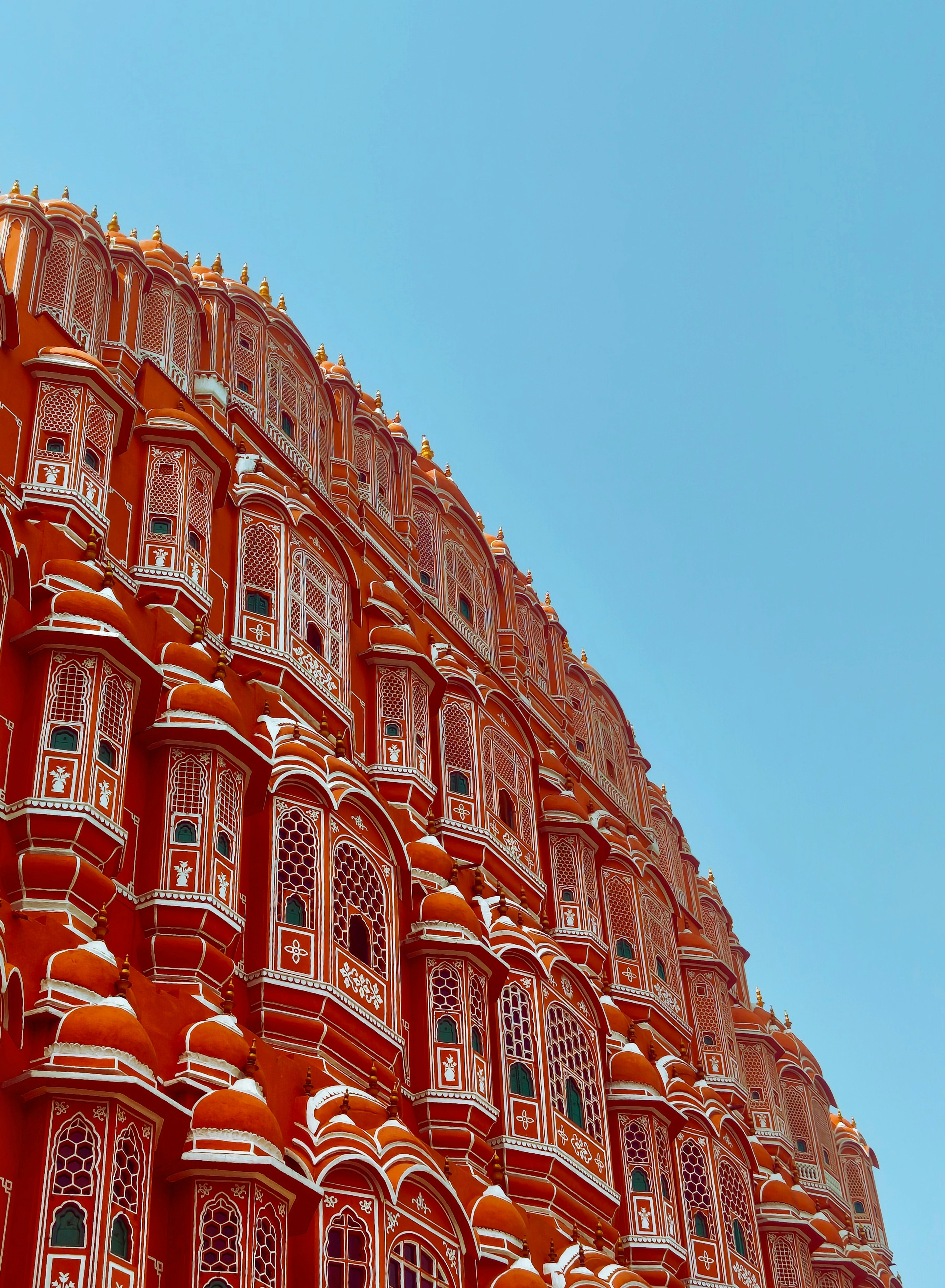 Intricate red building with many windows against blue sky