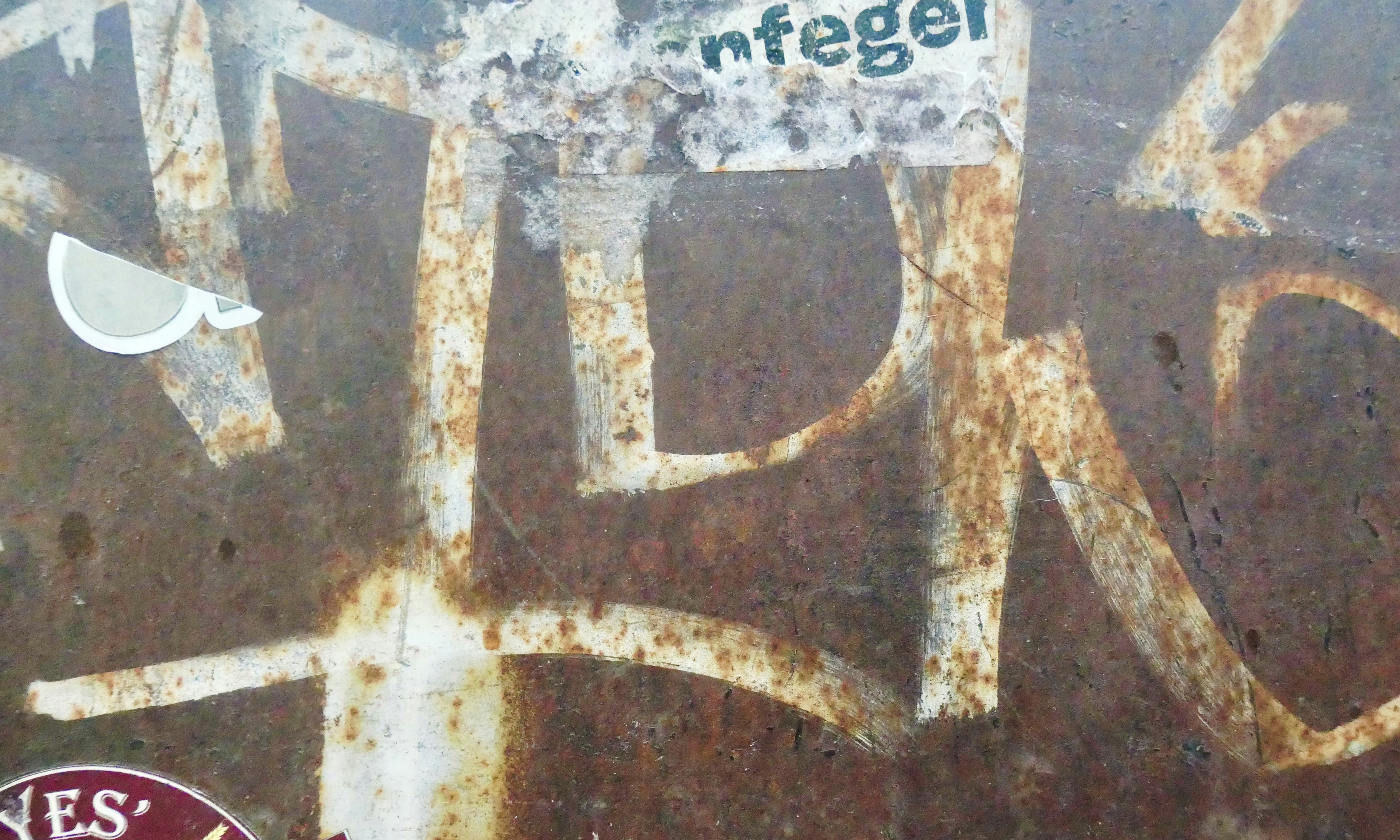 Rusted metal surface with graffiti and stickers