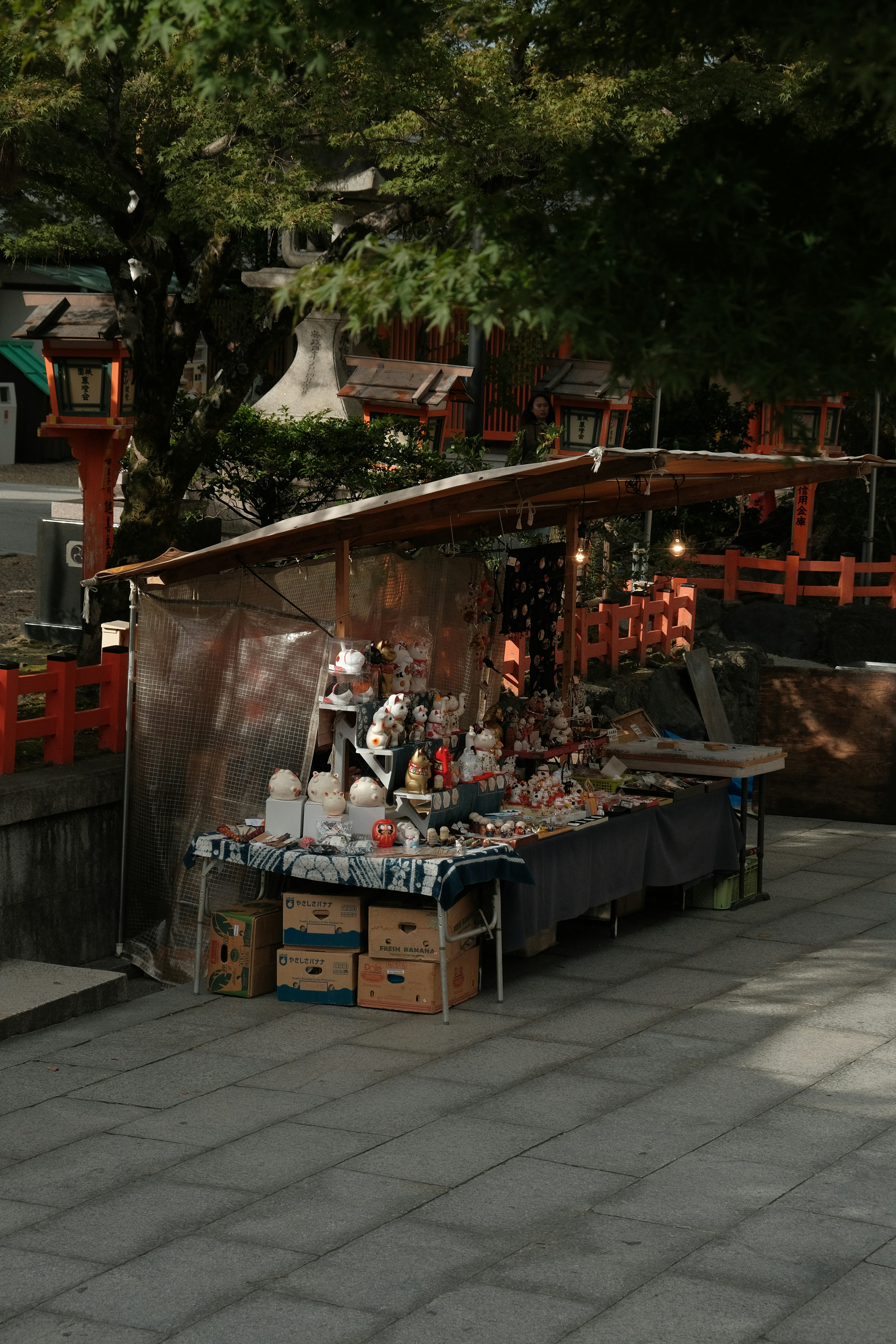 Ceramic Trinkets Under a Shrine Canopy: A Quiet Market Moment