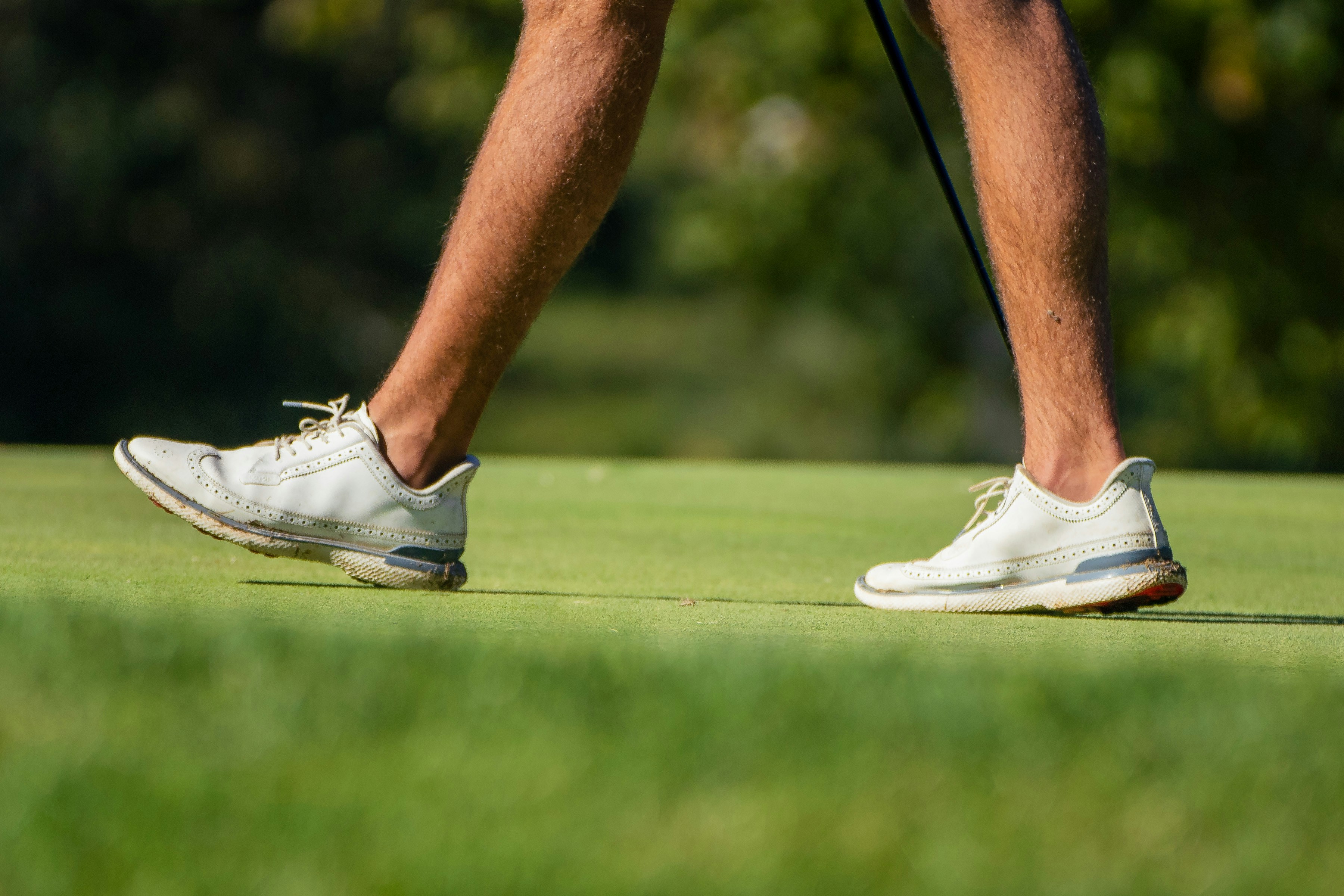 Golfer walking on a green with a club