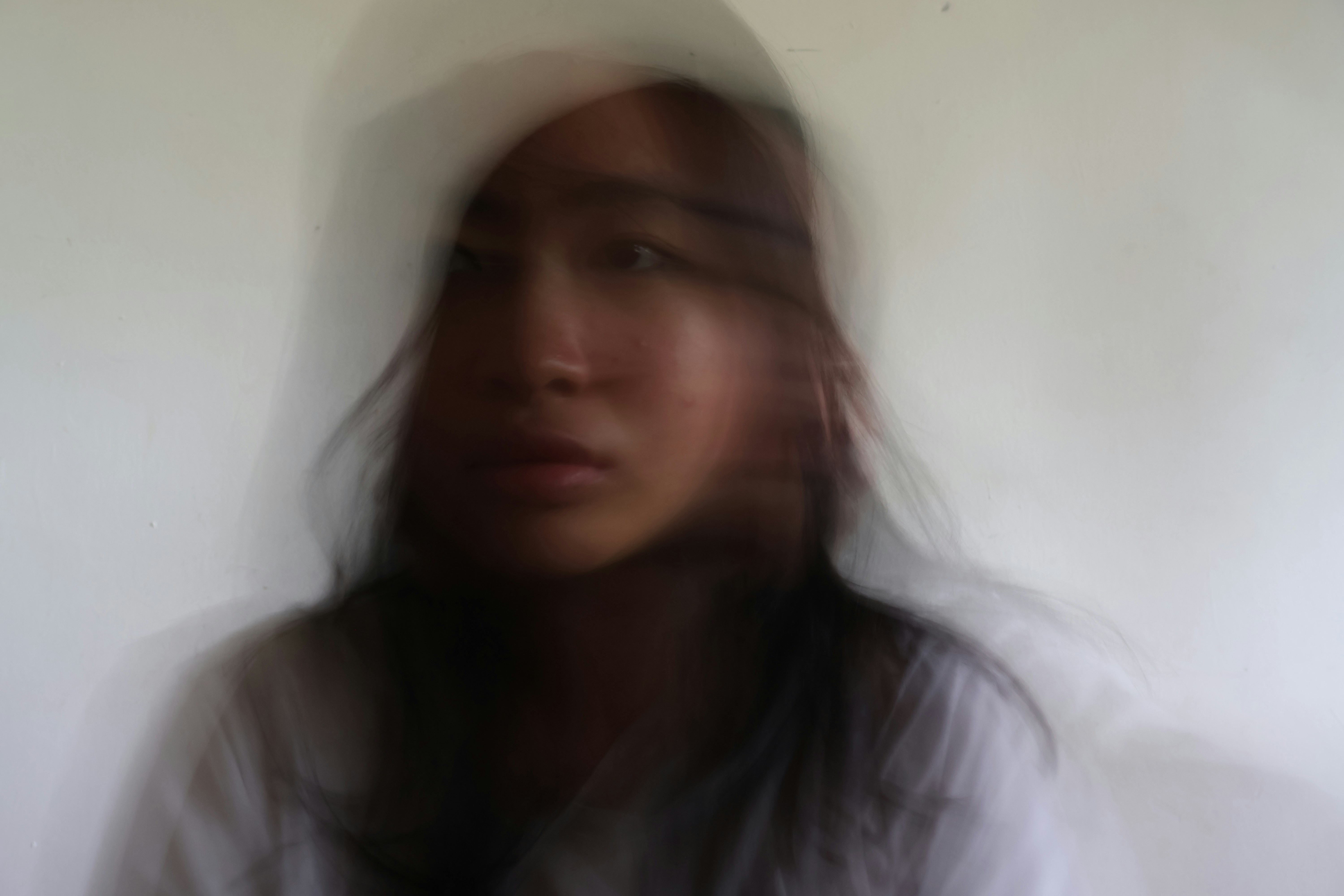 Between remembering and forgetting. | Blurred portrait of a young woman's face.