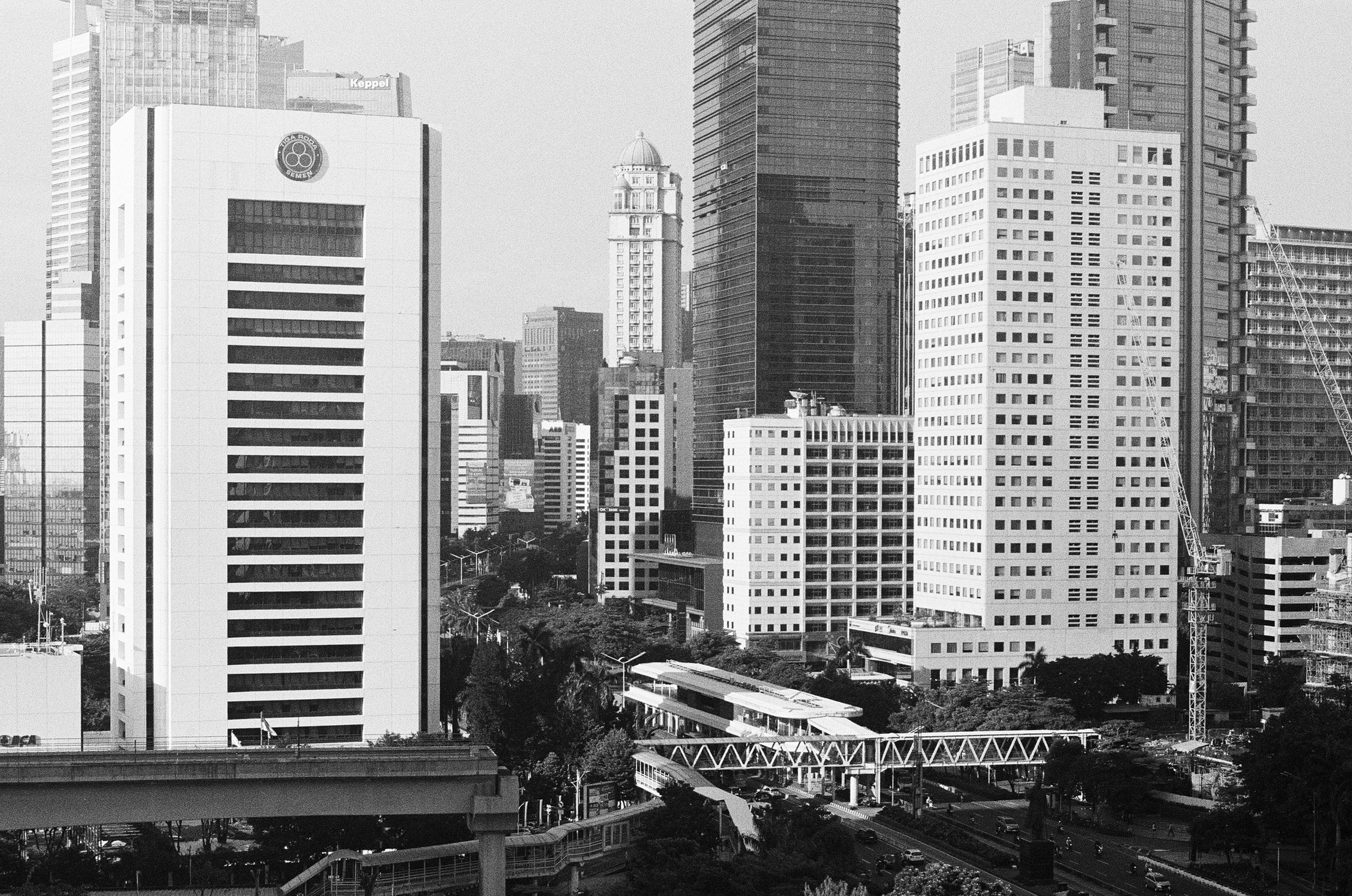 A black and white cityscape showcasing a blend of modern skyscrapers and architectural diversity in an urban environment.