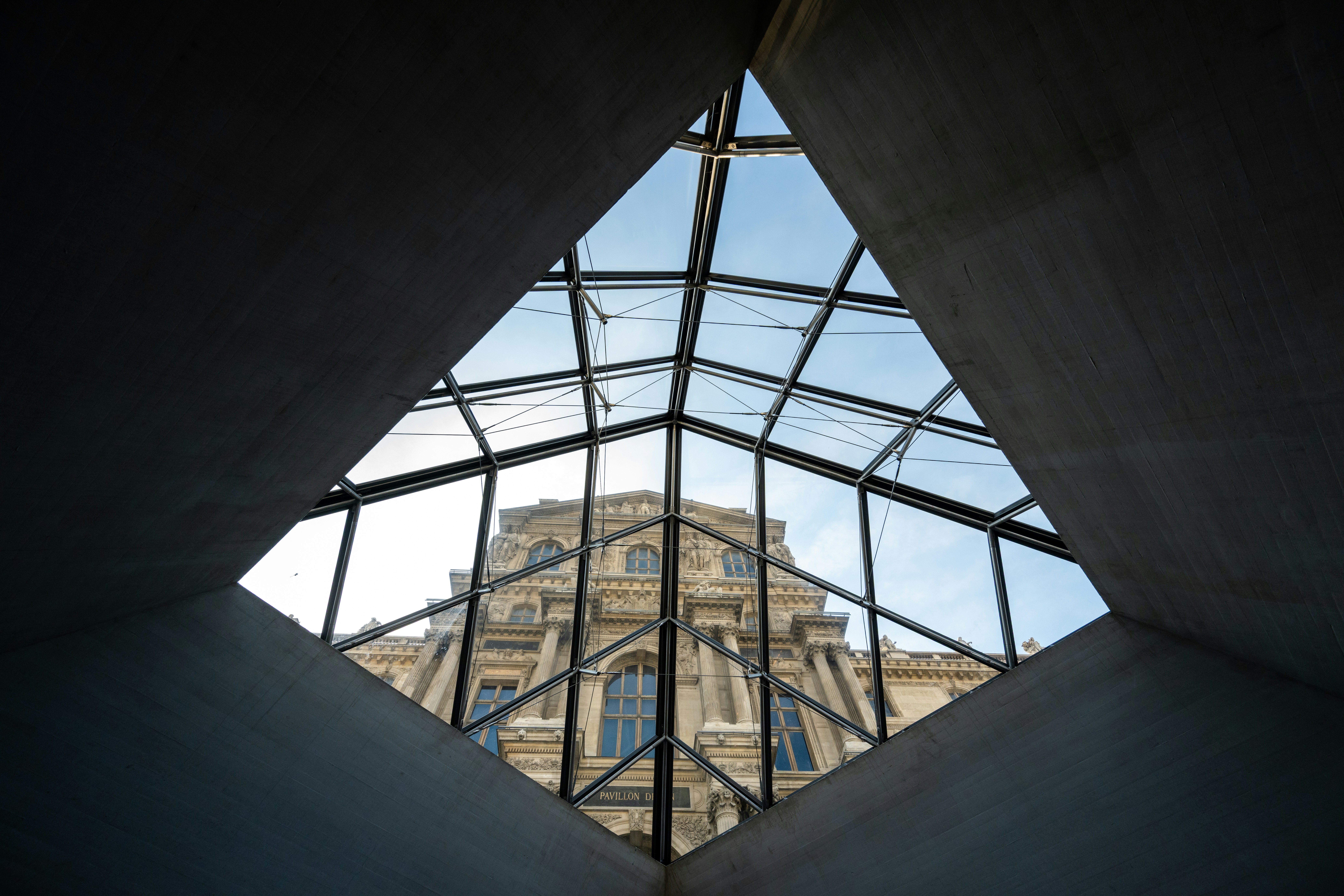 Building viewed through a geometric glass ceiling
