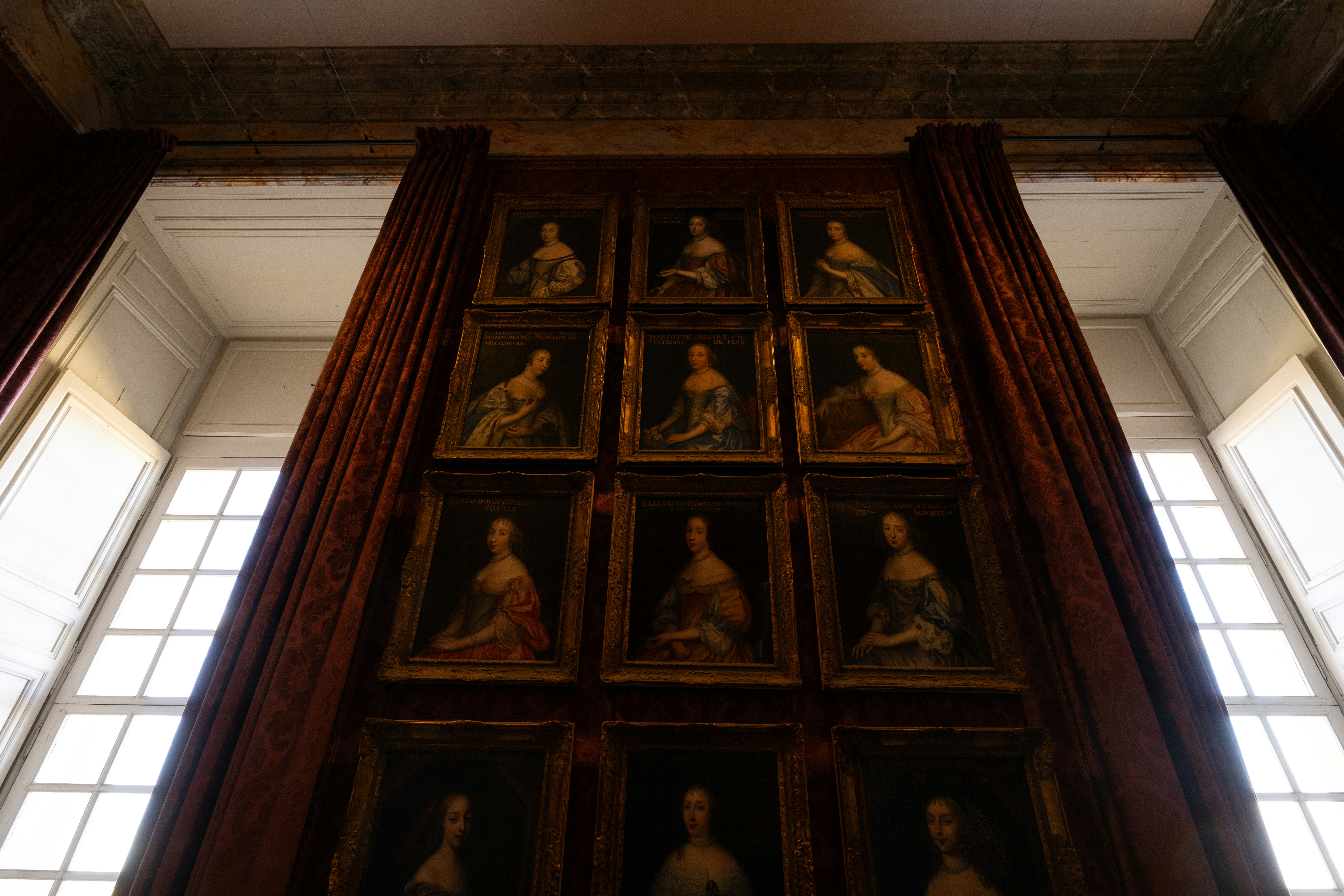 A collection of framed portraits displayed on a wall.