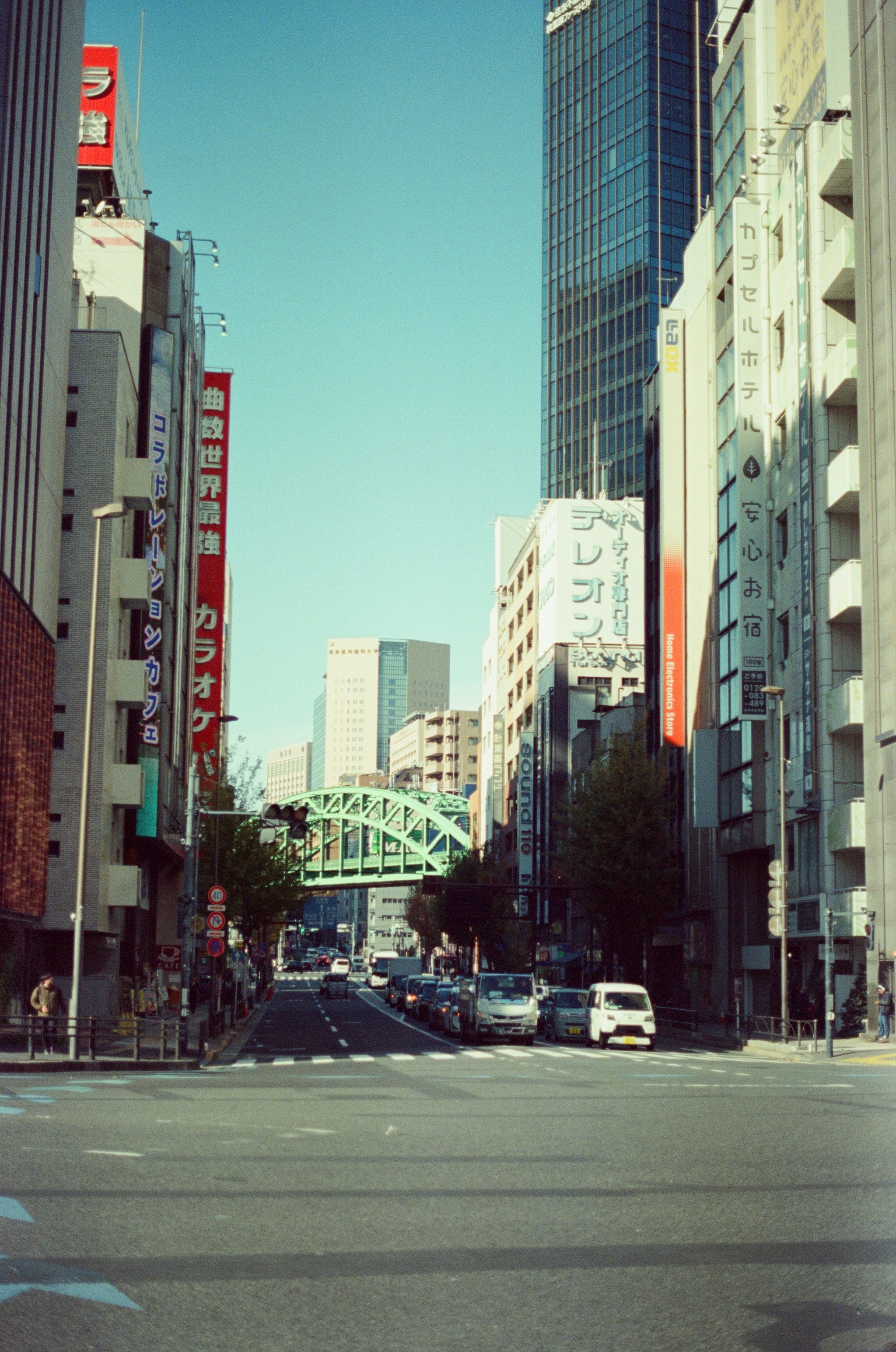 On 35mm film Kodak VISION 3 250D | City street with tall buildings and green bridge