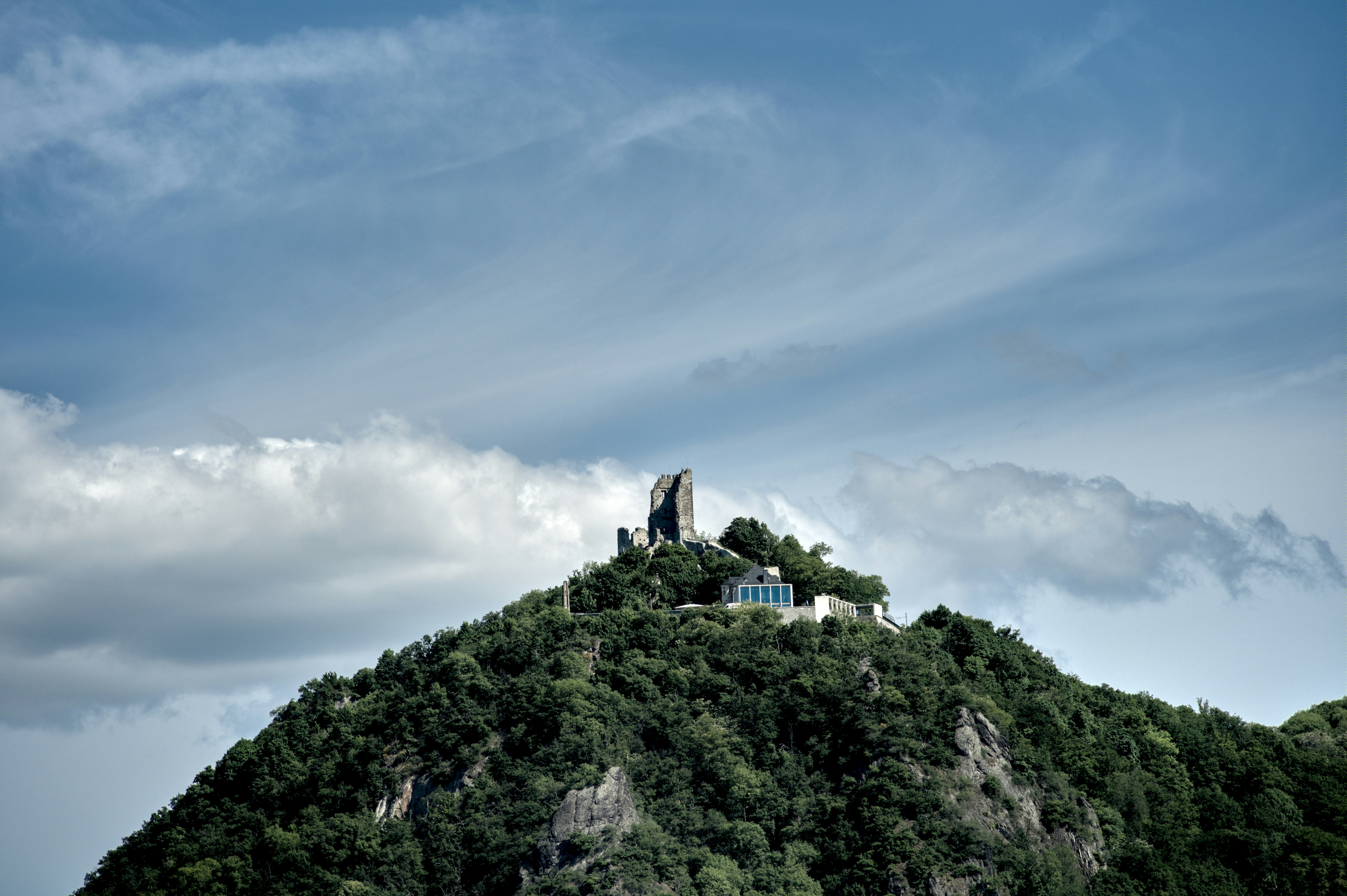Der Drachenfels ist einer der geheimnisfolsten Orte in Deutschland | Castle ruins atop a lush green mountain under clouds