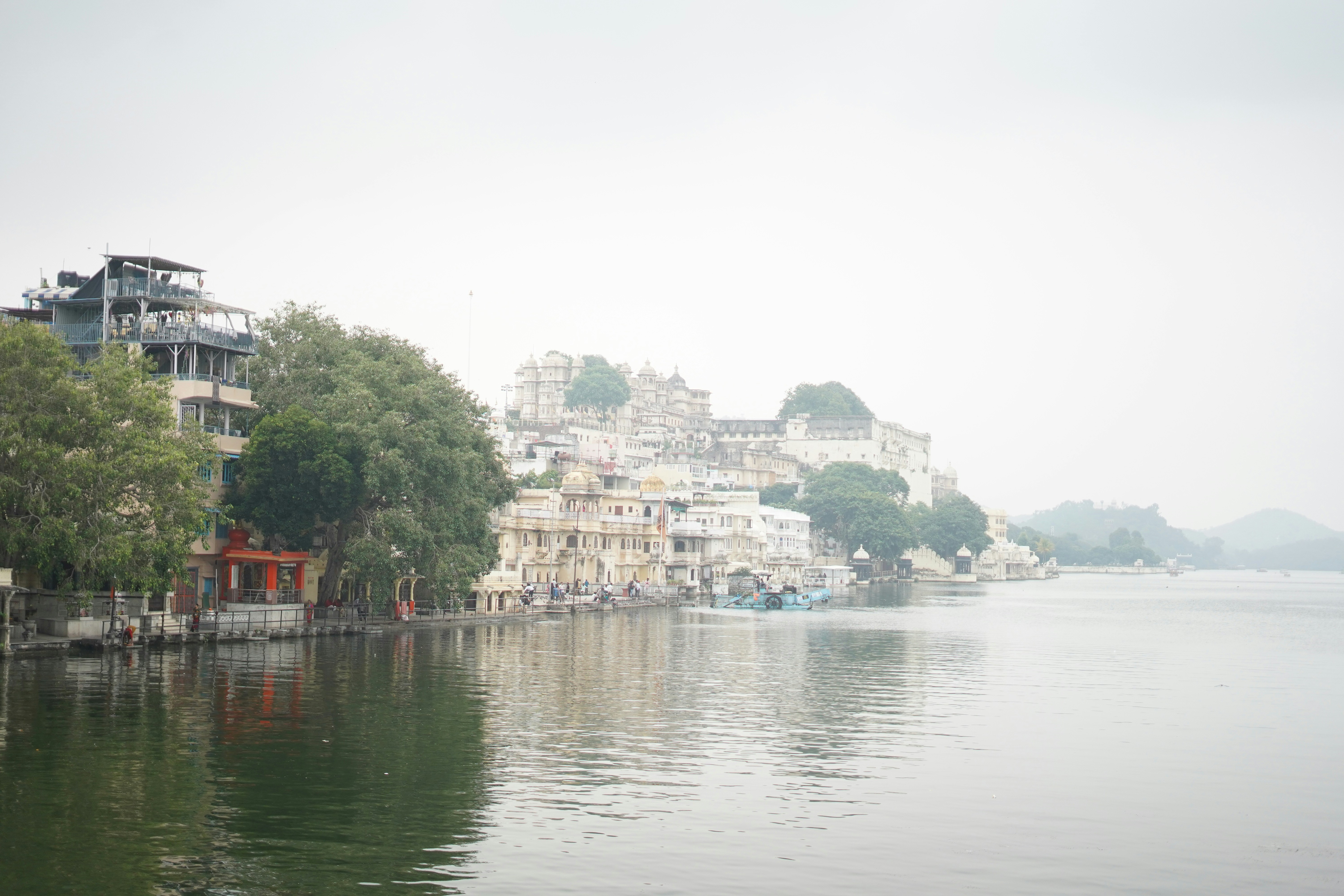 Buildings line a calm lake with reflections.