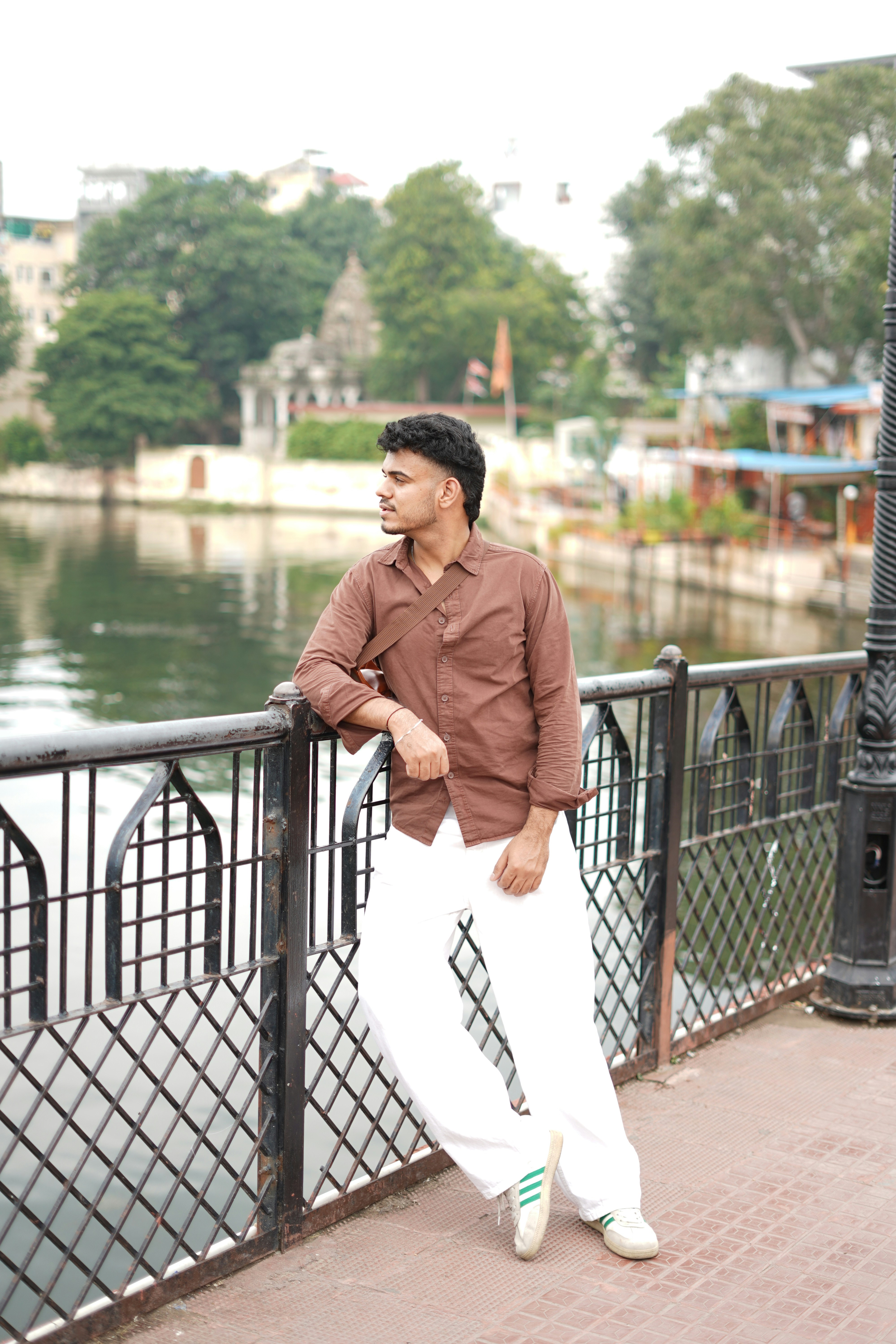 Riverside Contemplation: A Man in Brown by the Railings