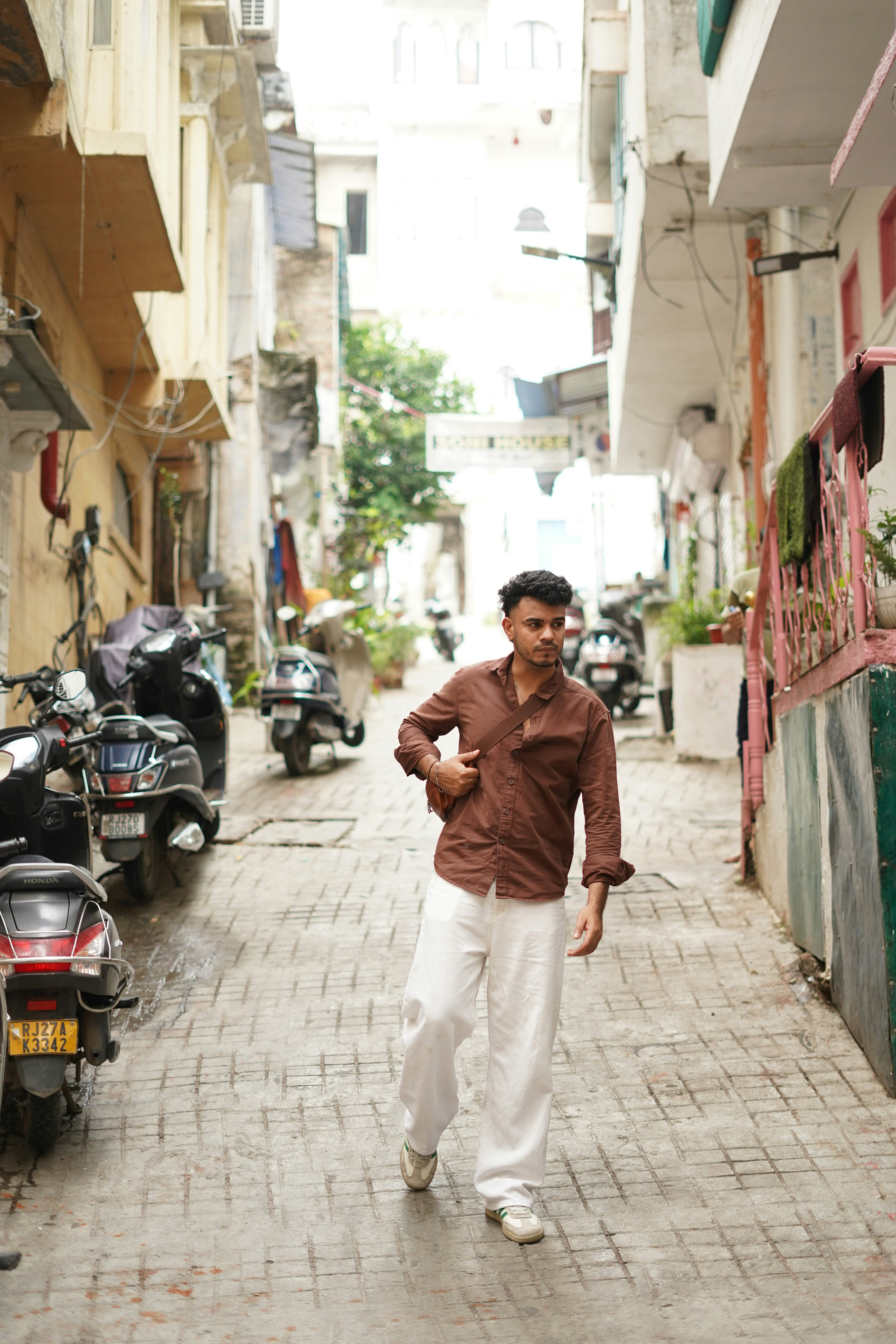 Man walking down a narrow urban alleyway.