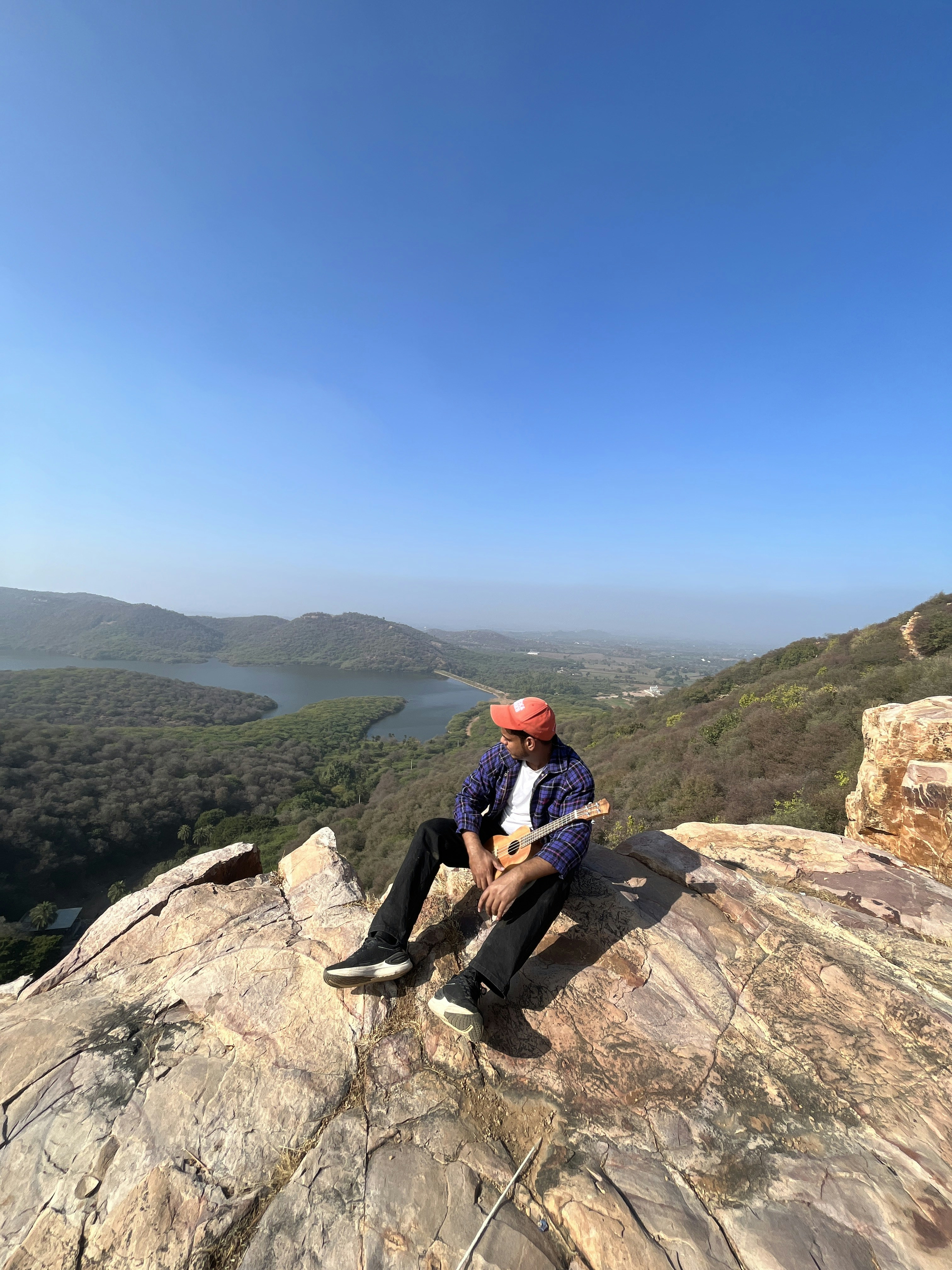 Granite Promontory Serenade: A Guitarist Above a Lake-Valley Vista