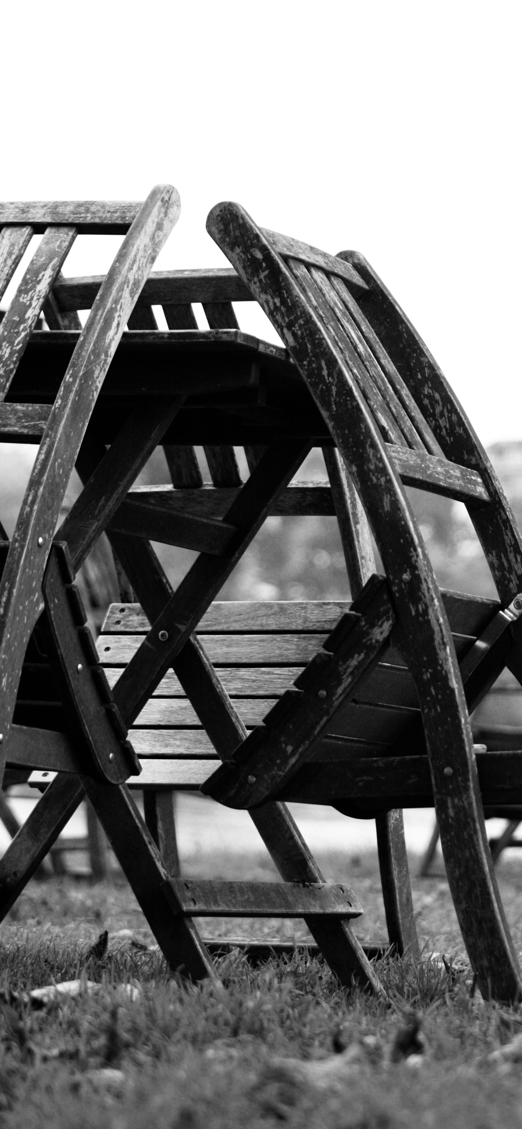Stühle in einer wunderbaren Herbst Stadt. Die Wärme des Sommers immer noch präsent ist. | Stacked weathered wooden chairs on grass