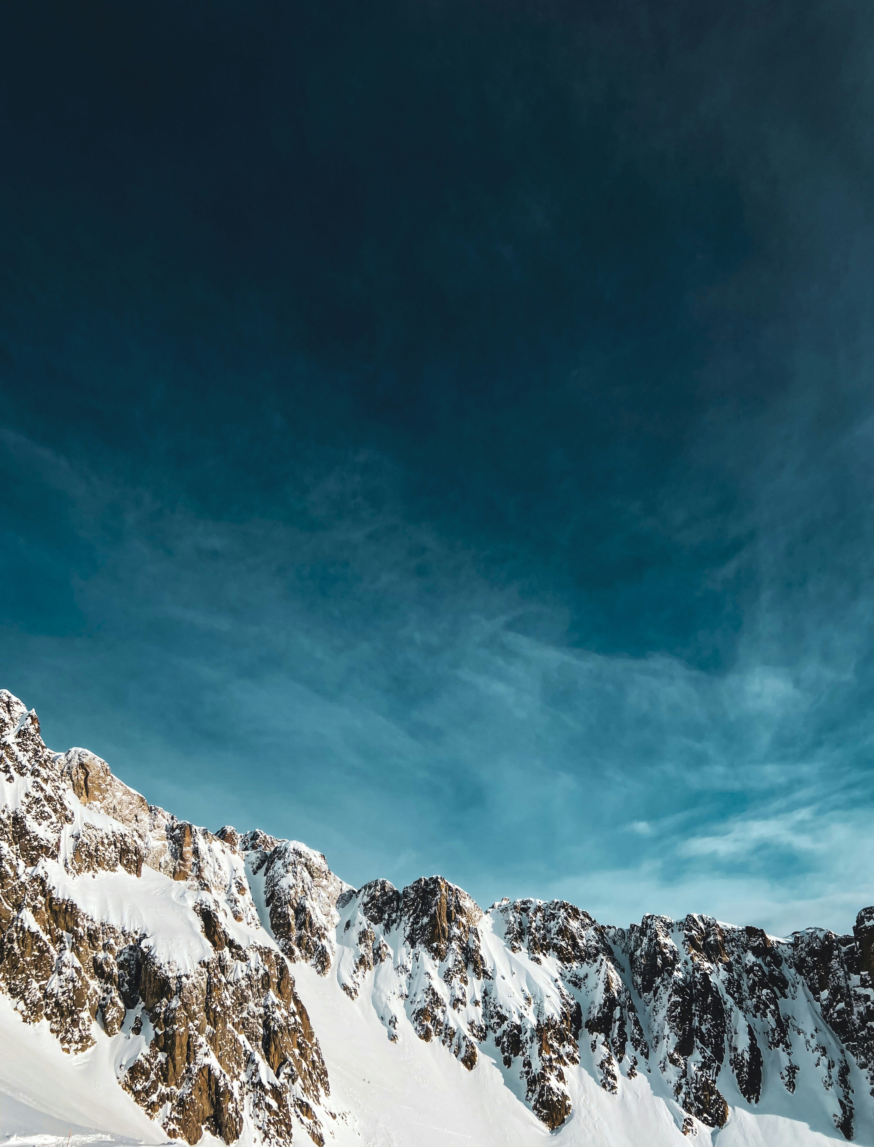 Snow covered mountain range under a deep blue sky
