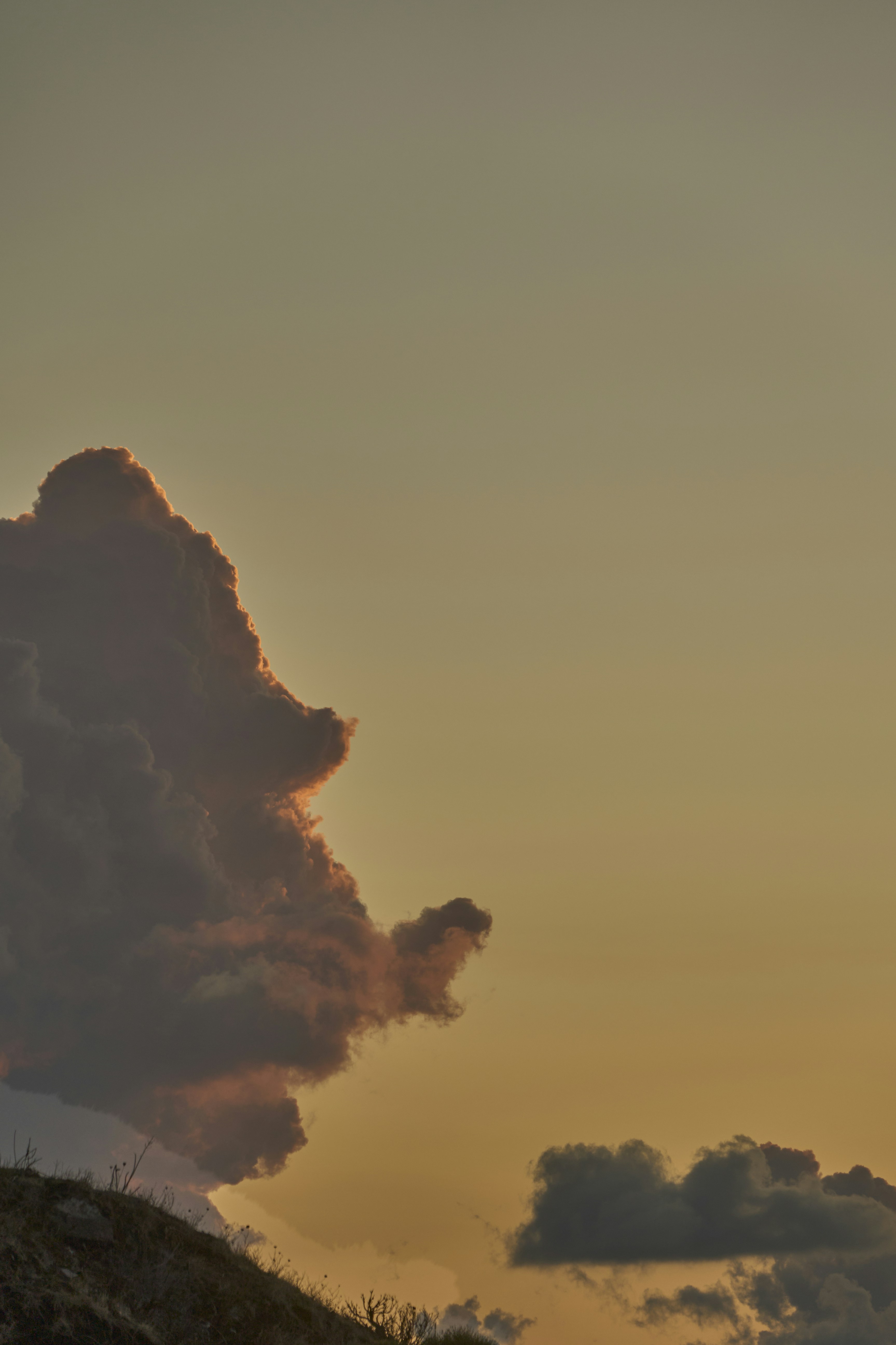 Dramatic cloud formation against a golden sunset sky.