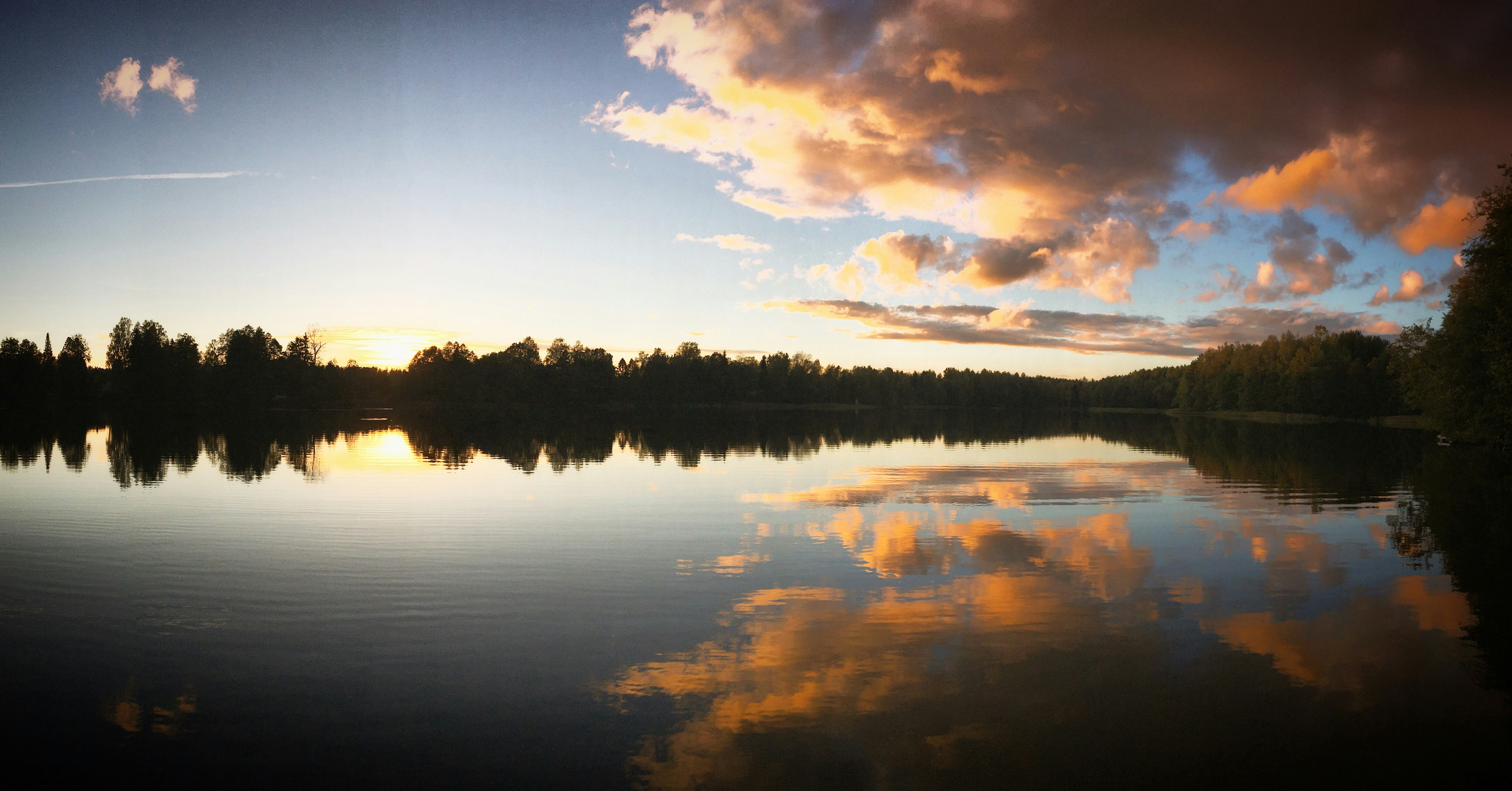 Serene Lake Kiidjärv reflects golden hour clouds and forest, Kiidjärve, Põlvamaa, Estonia, September 2018 | Sunset clouds reflected in a calm lake