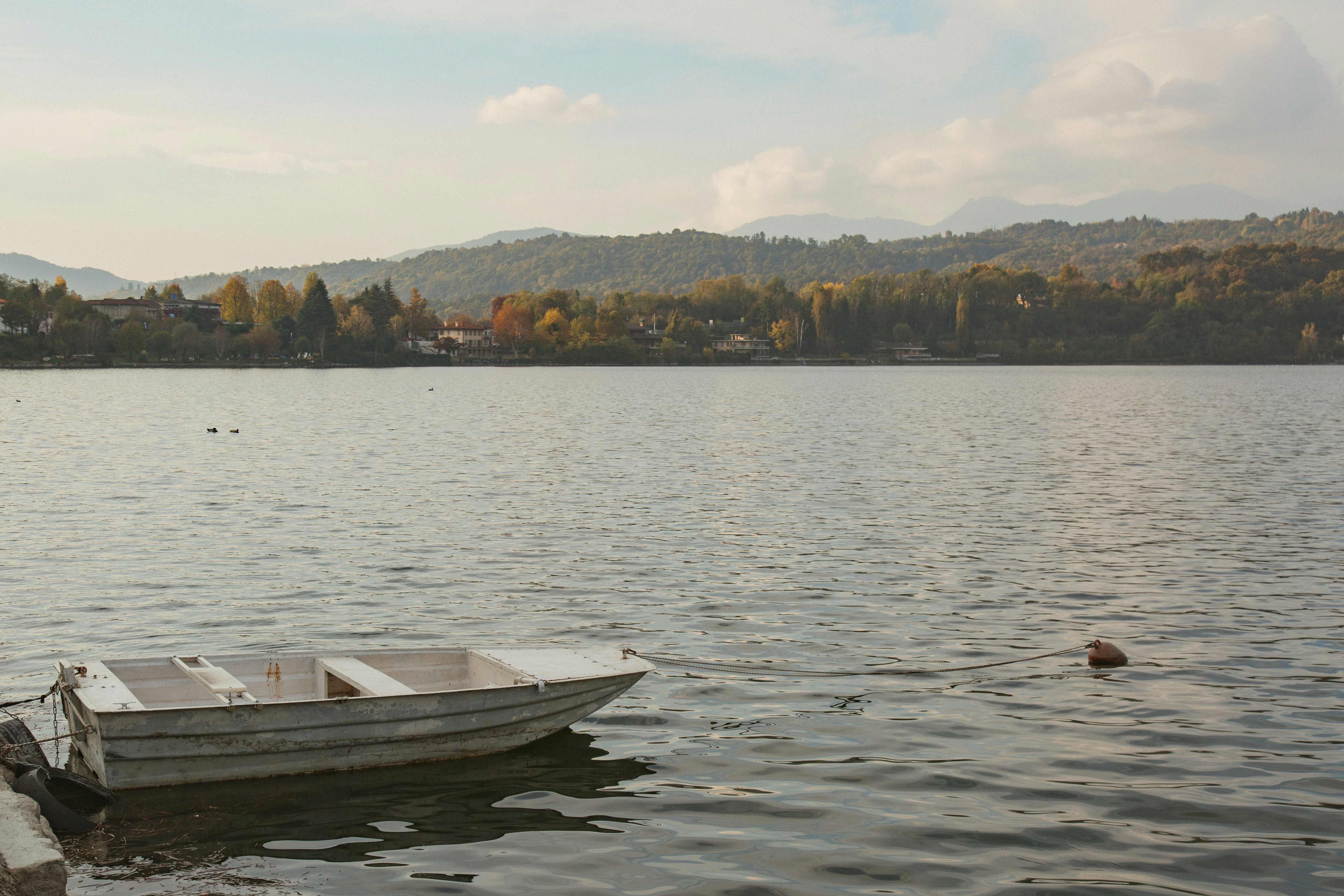 Hello =) Follow my journey on insta: I_am_simoesse | A small white boat floats on a calm lake.