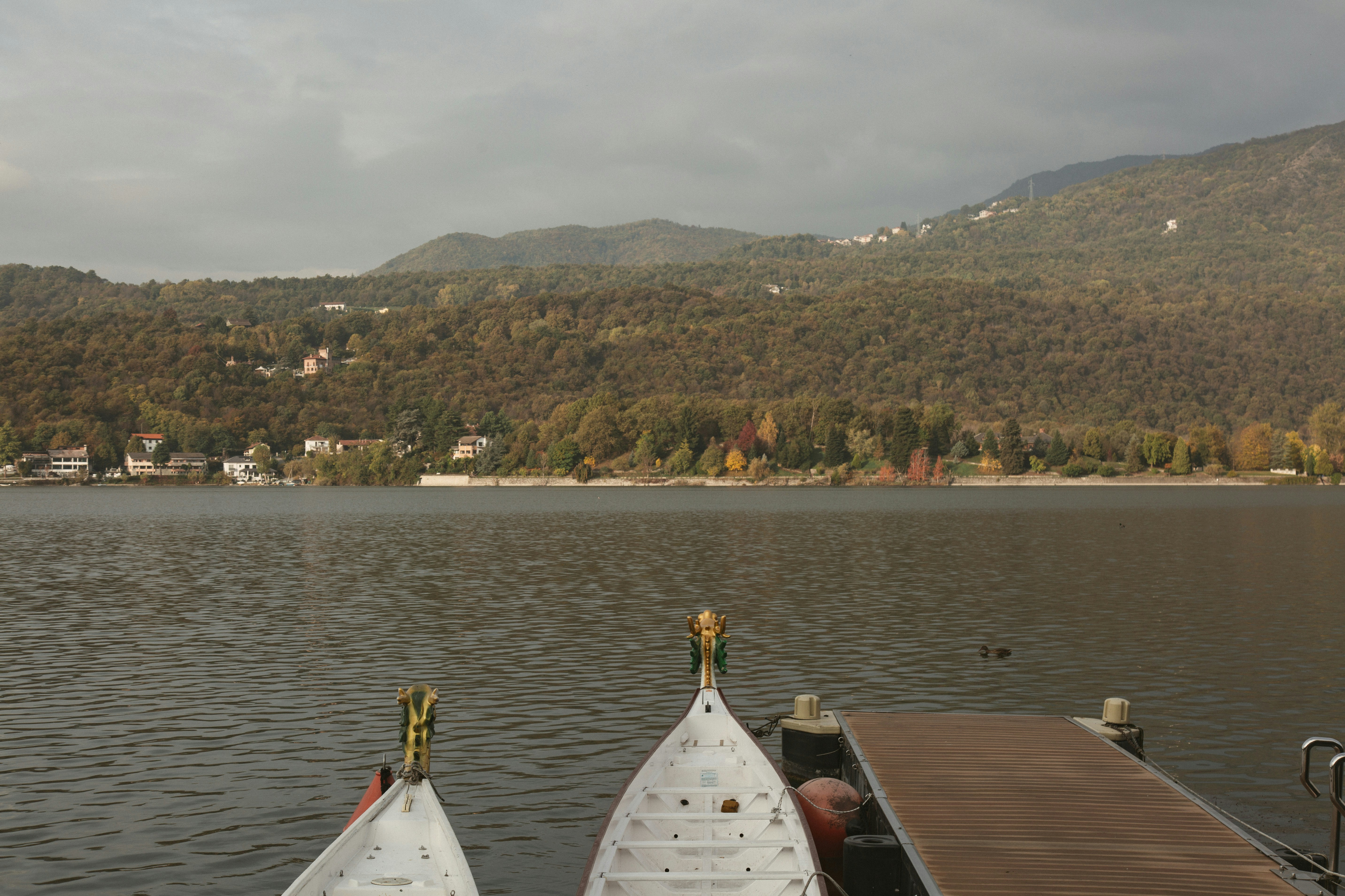 Docks at the Quiet Lake: Boats Point Toward a Distant Hillside