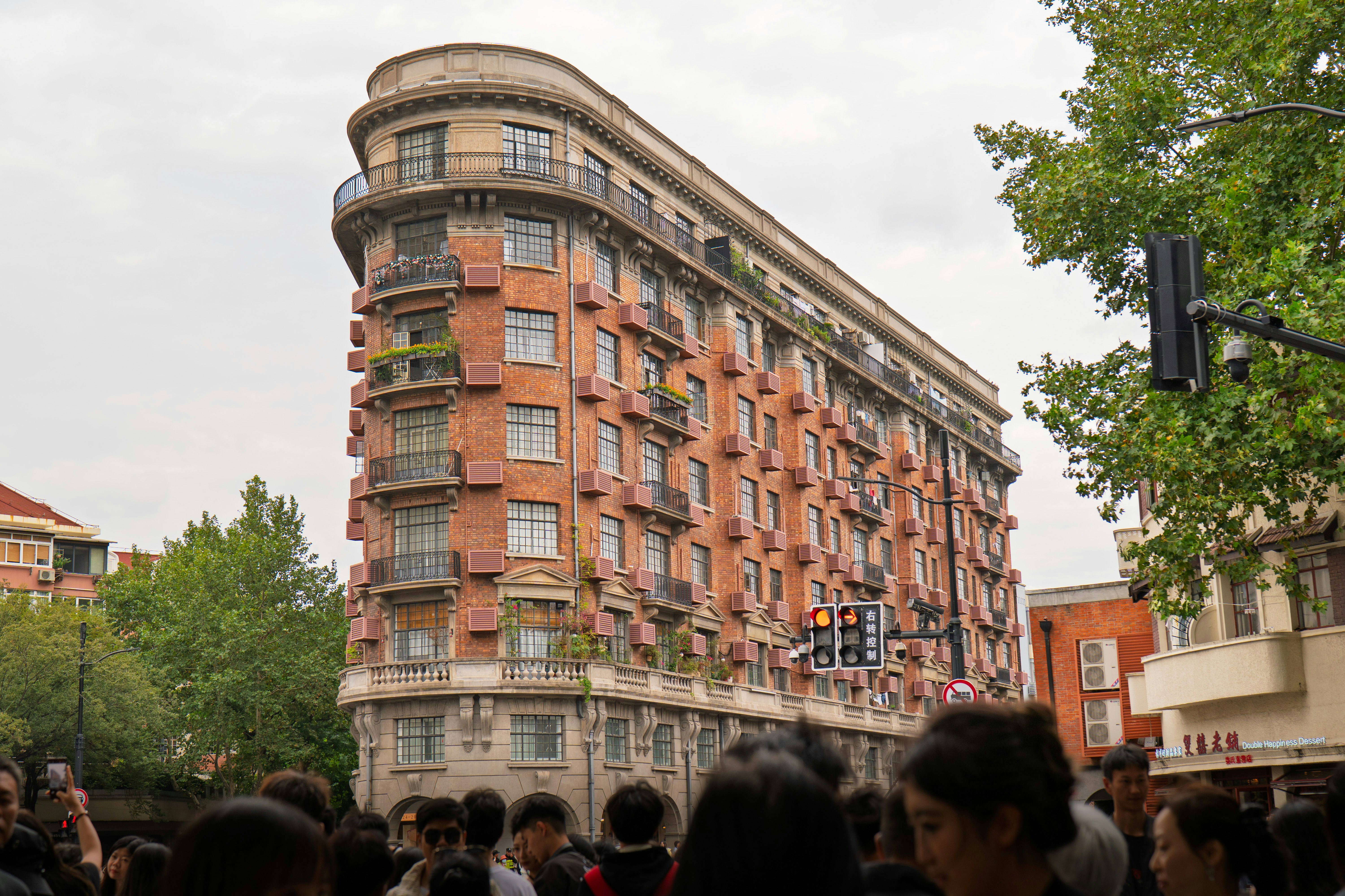 Curved brick building with many windows and balconies.