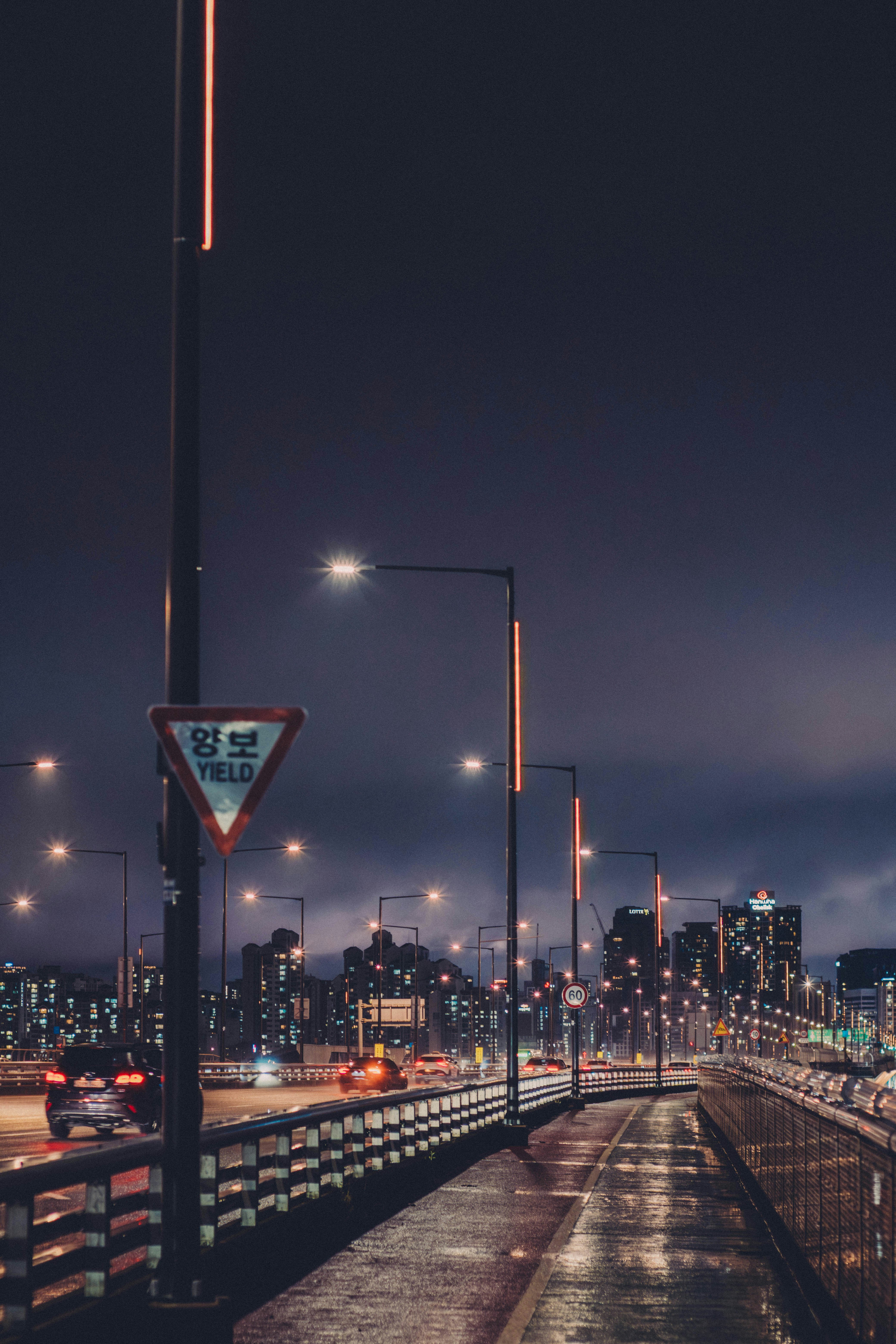 City bridge at night with streetlights and cars.