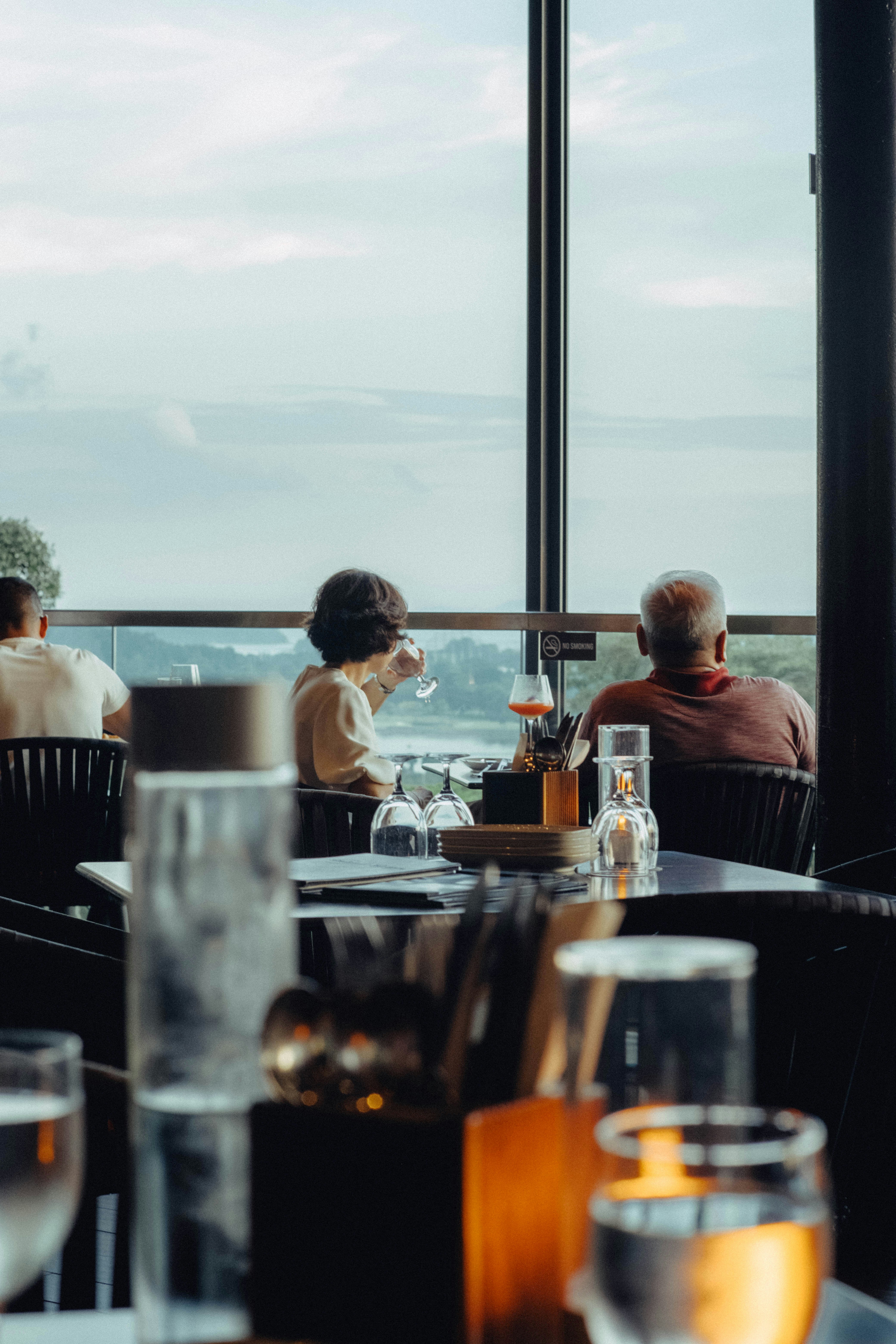 People dining at tables by a large window