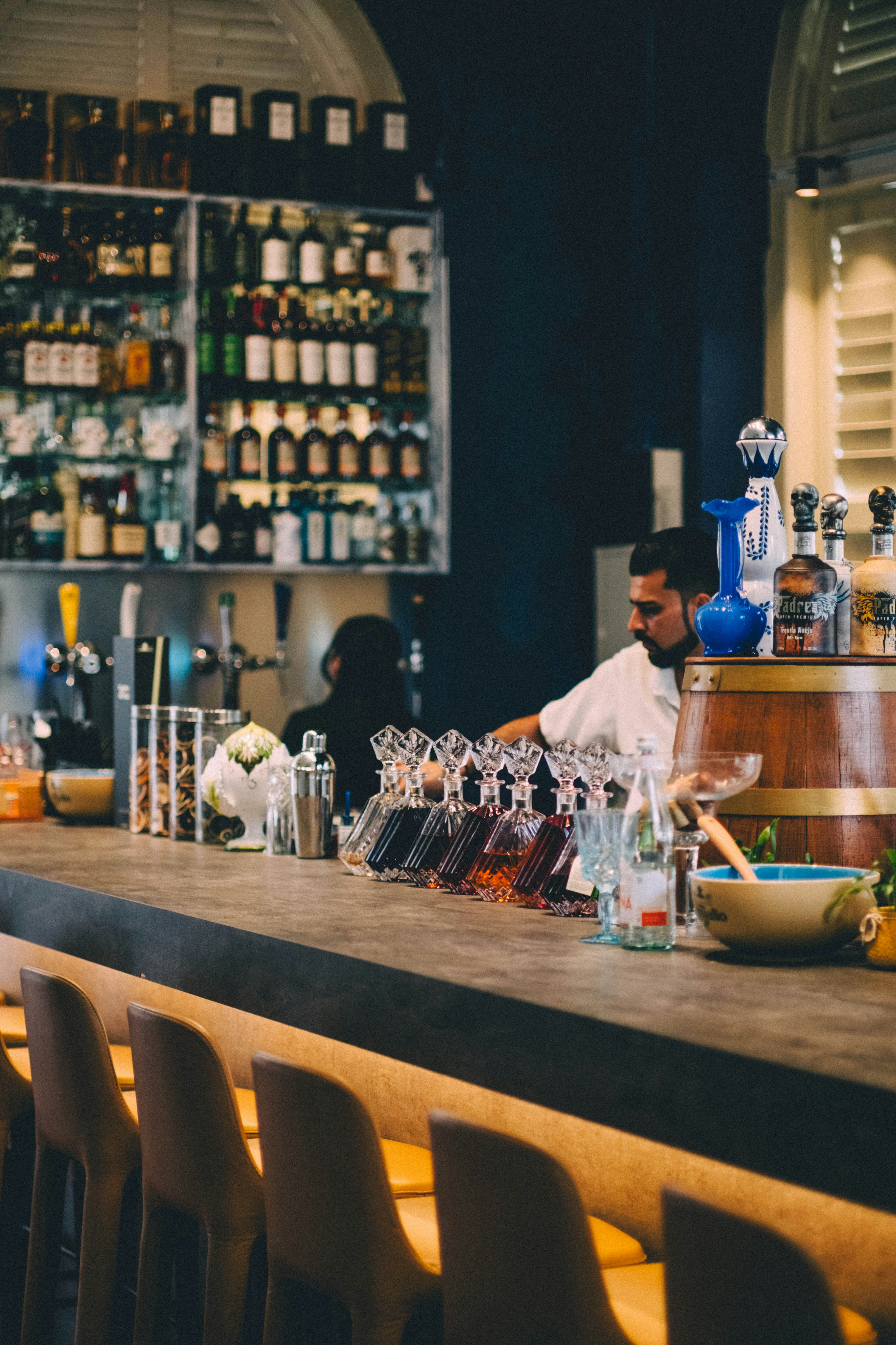 Bartender preparing drinks behind a bar counter