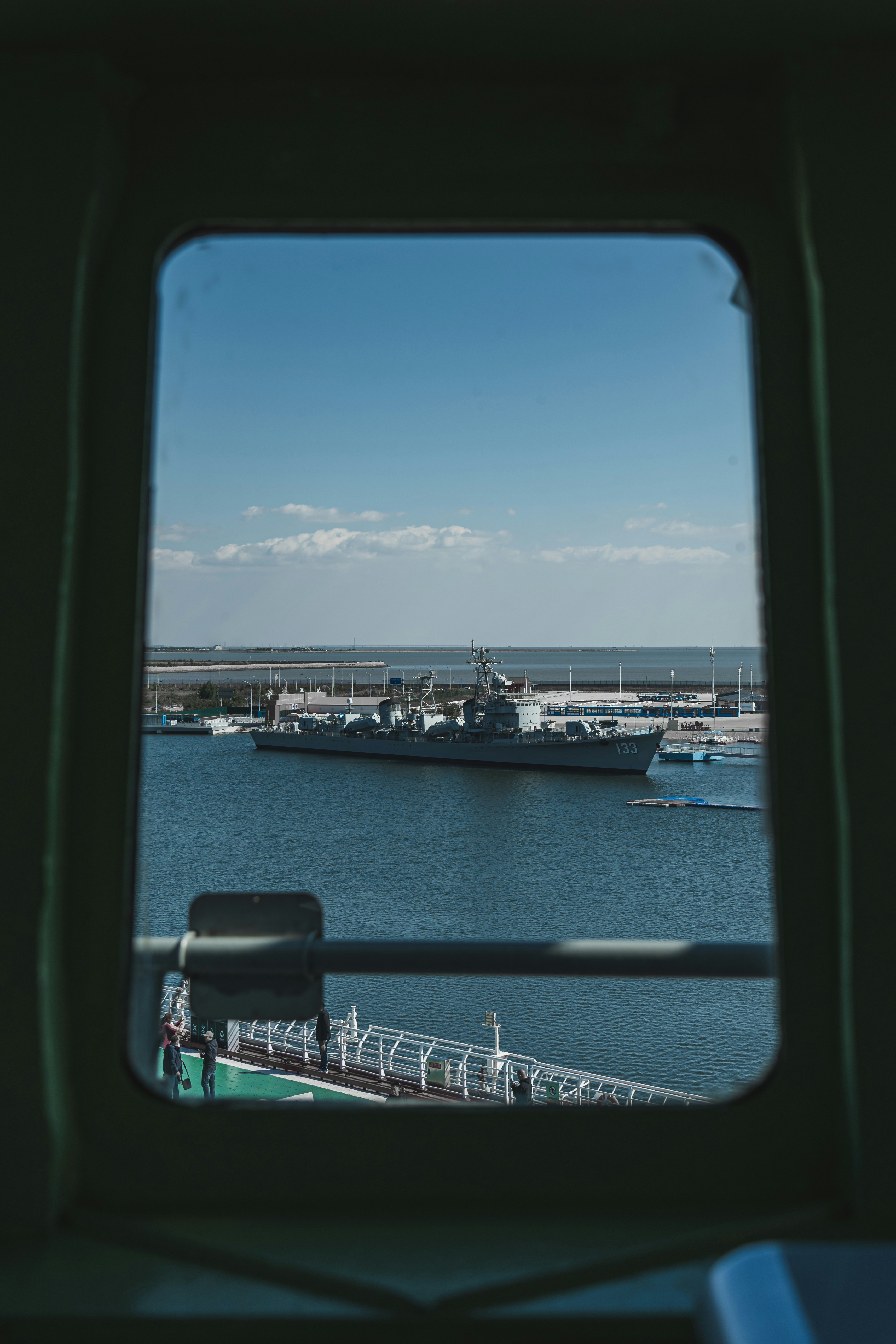 Looking at the frigates in the distance from the Kiev aircraft carrier | Warship docked in a harbor under a clear sky