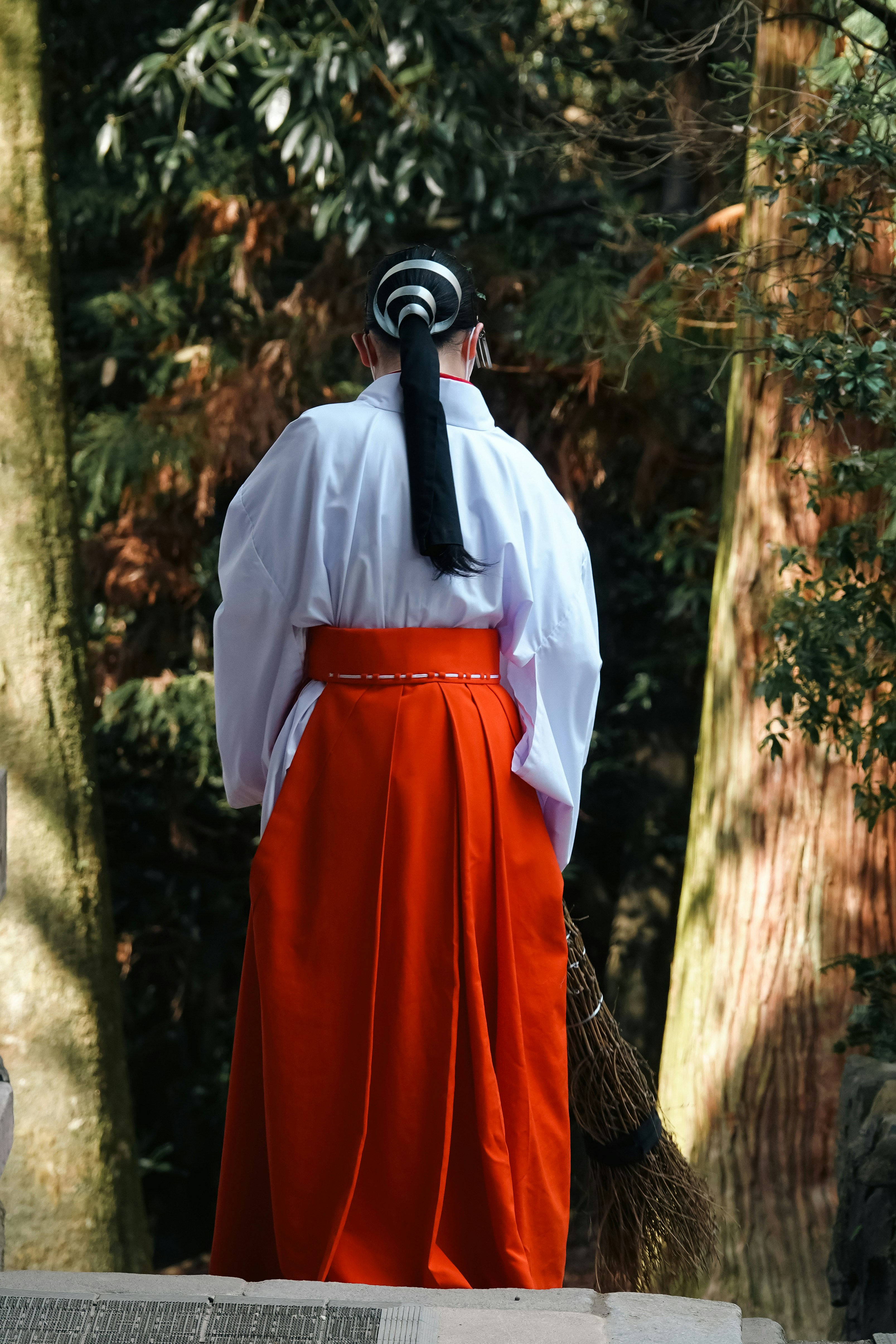 Person in traditional japanese attire with orange skirt.
