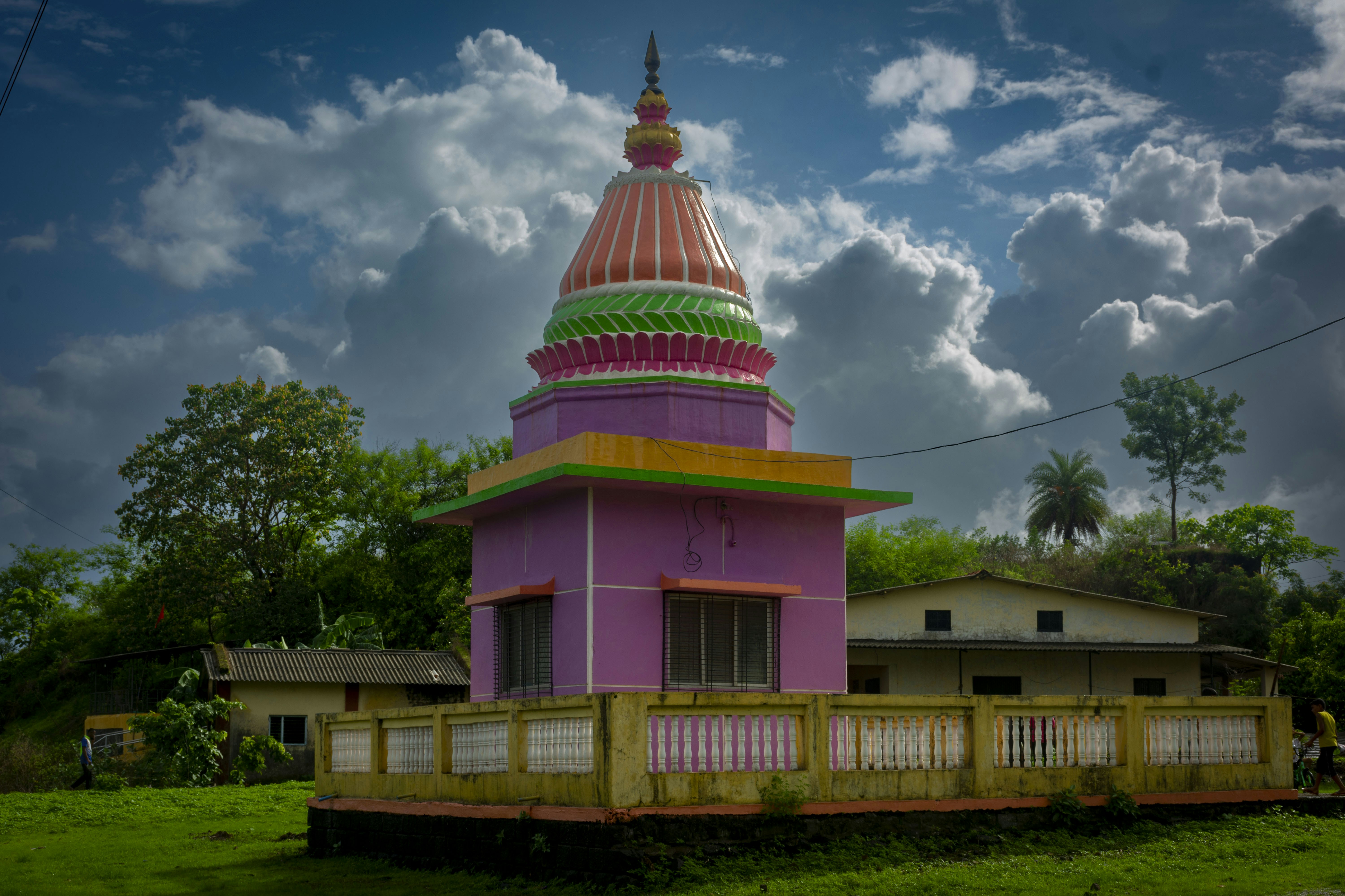 Pastel Stupa in the Countryside: A Colorful Temple Against a Clouded Sky