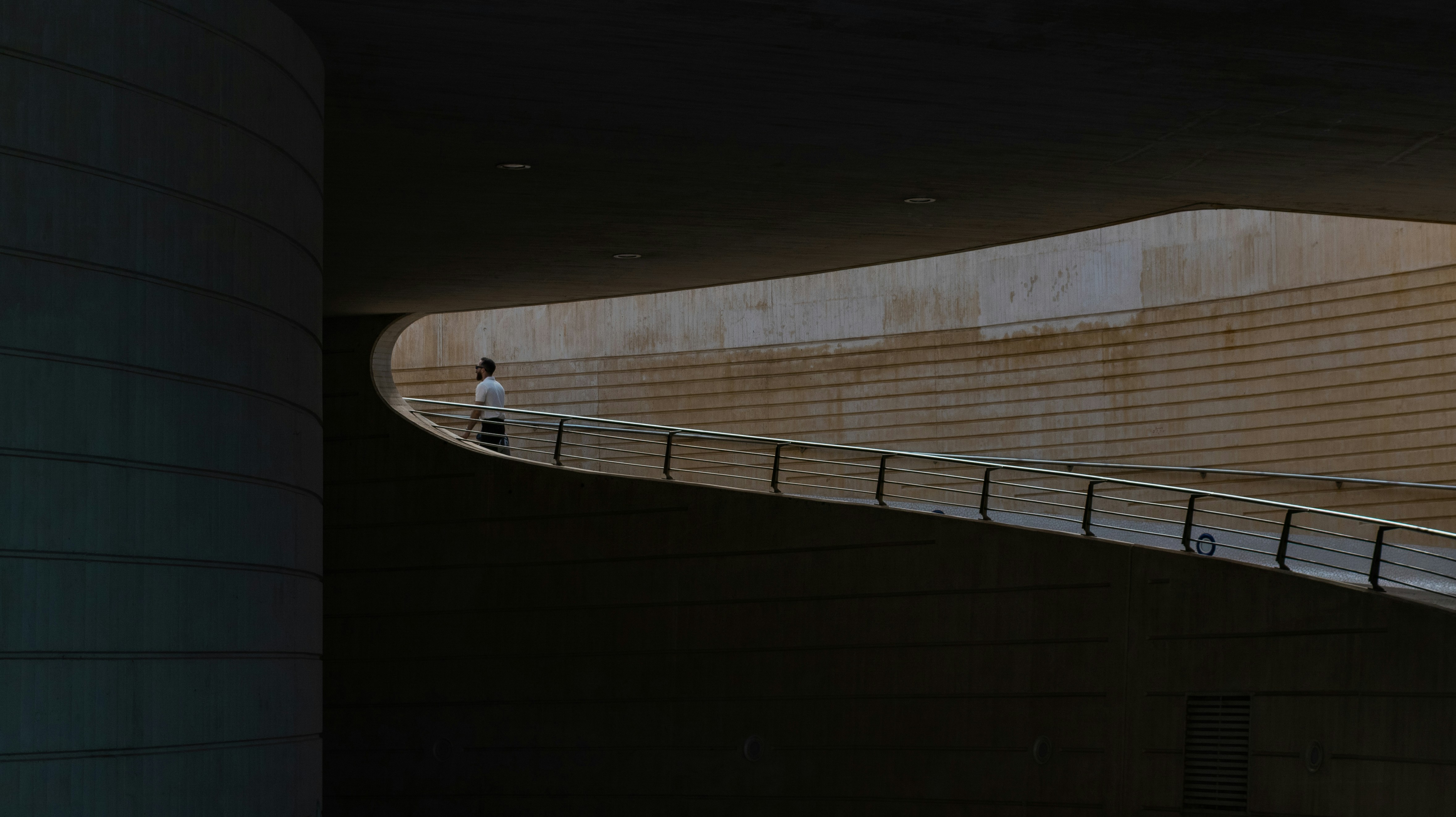 A person walks on a curved elevated walkway.
