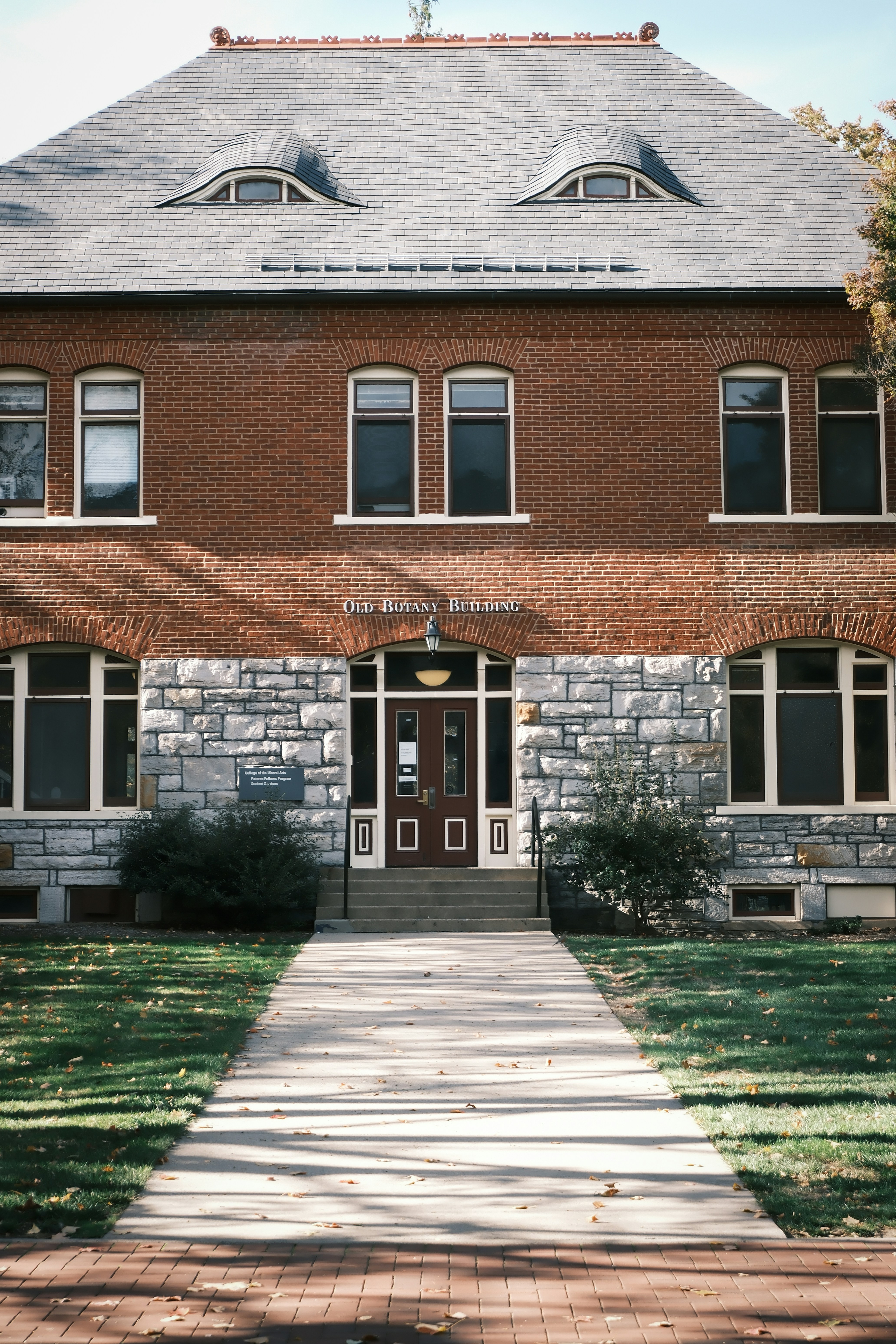 Brick building with stone base and dormer windows.