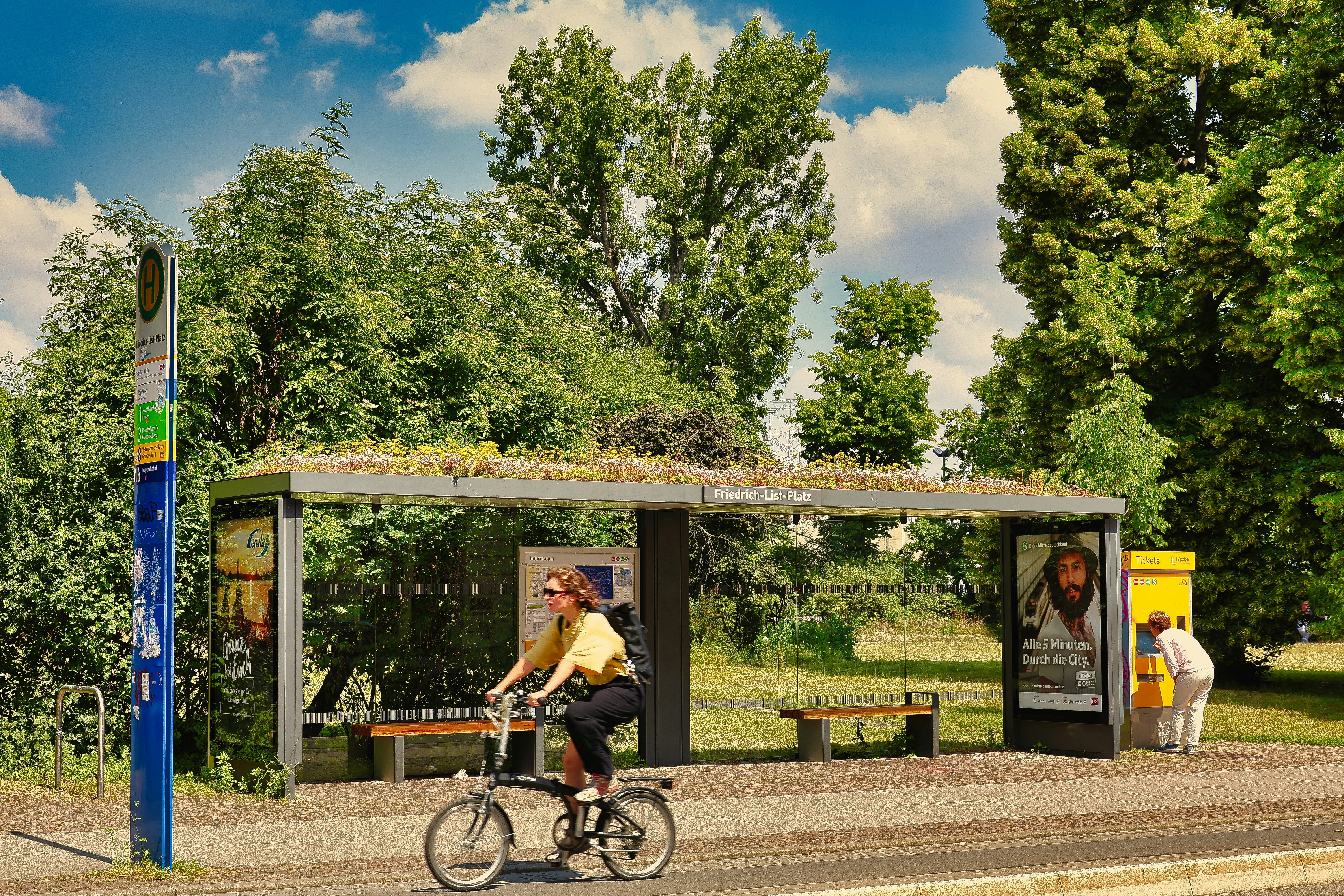 Morning Ride Past a Glass-Walled Transit Shelter