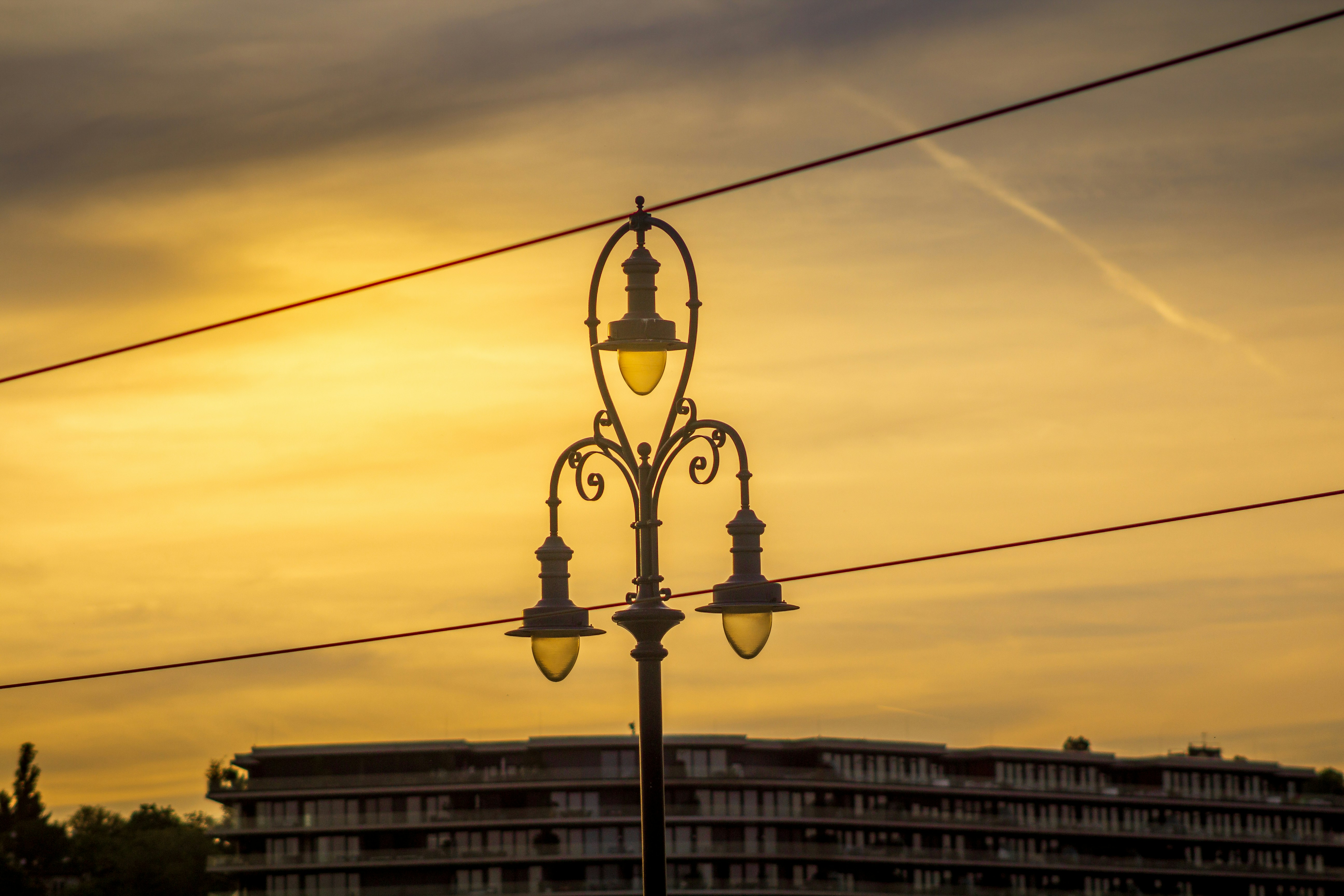 Ornate street lamp against a dramatic sunset sky.