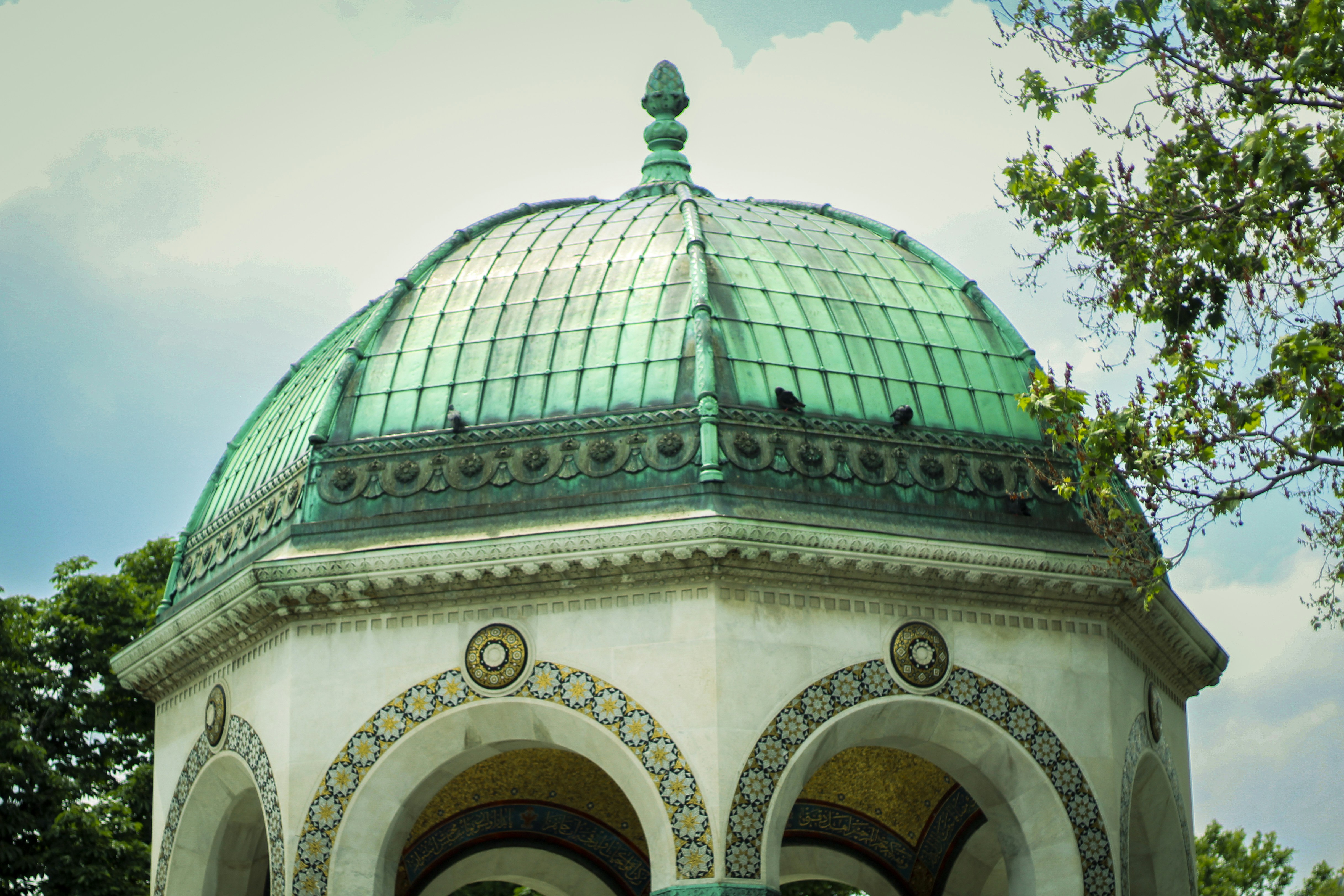 Green domed structure with arched openings