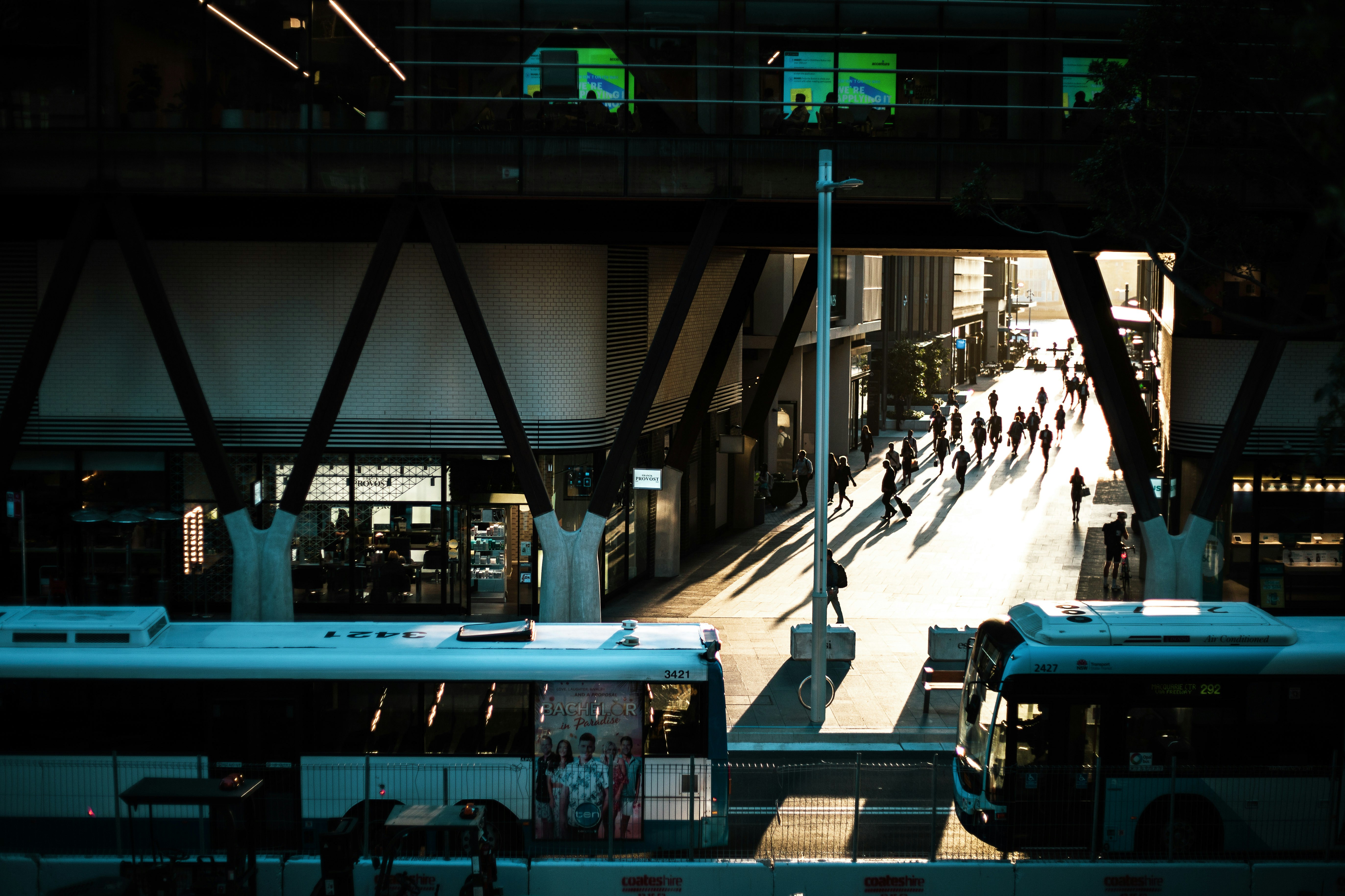 Morning commute, Sydney CBD | People walking down a sunlit city street with buses.