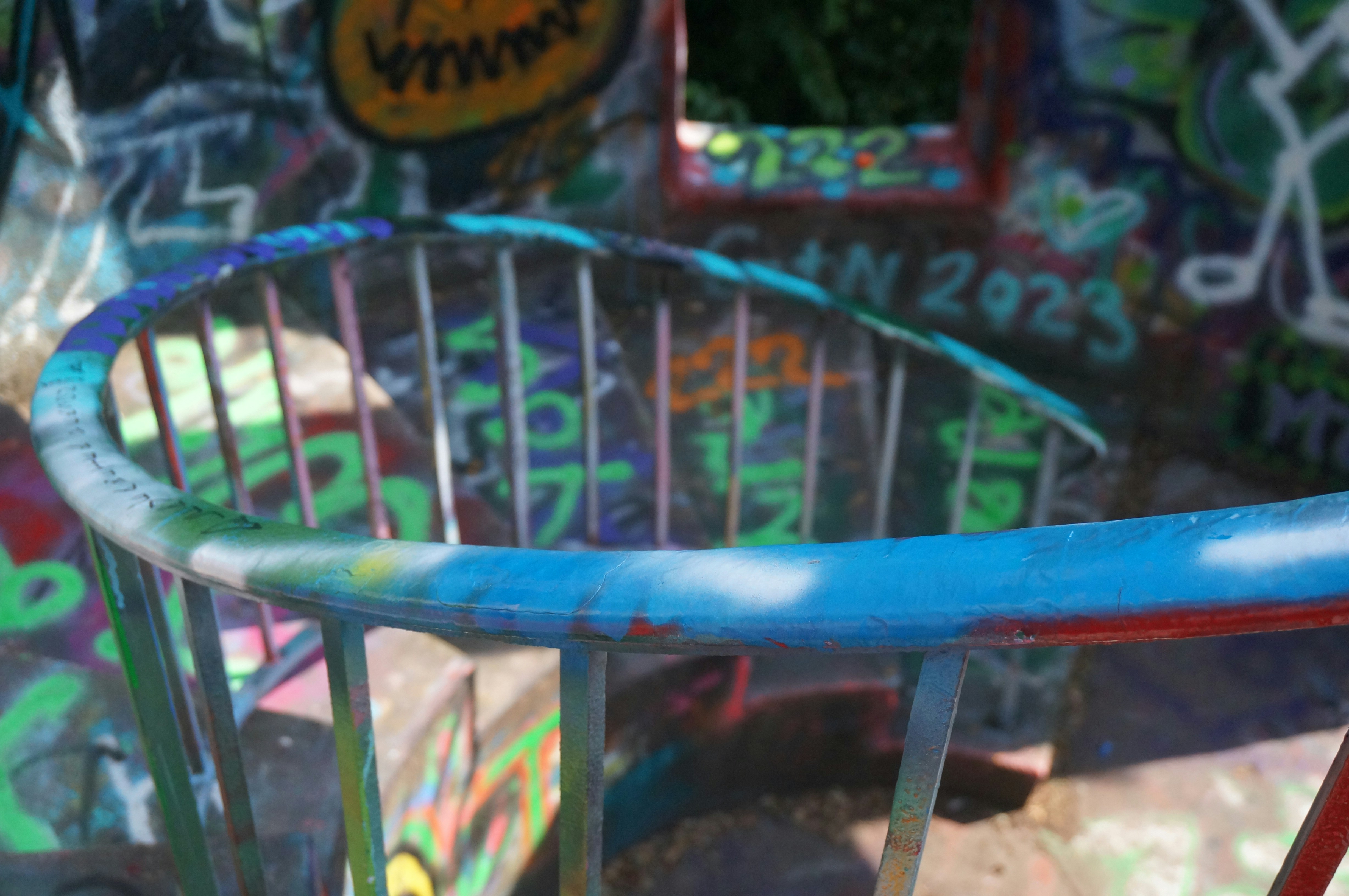 Graffiti-covered structure with a blue railing
