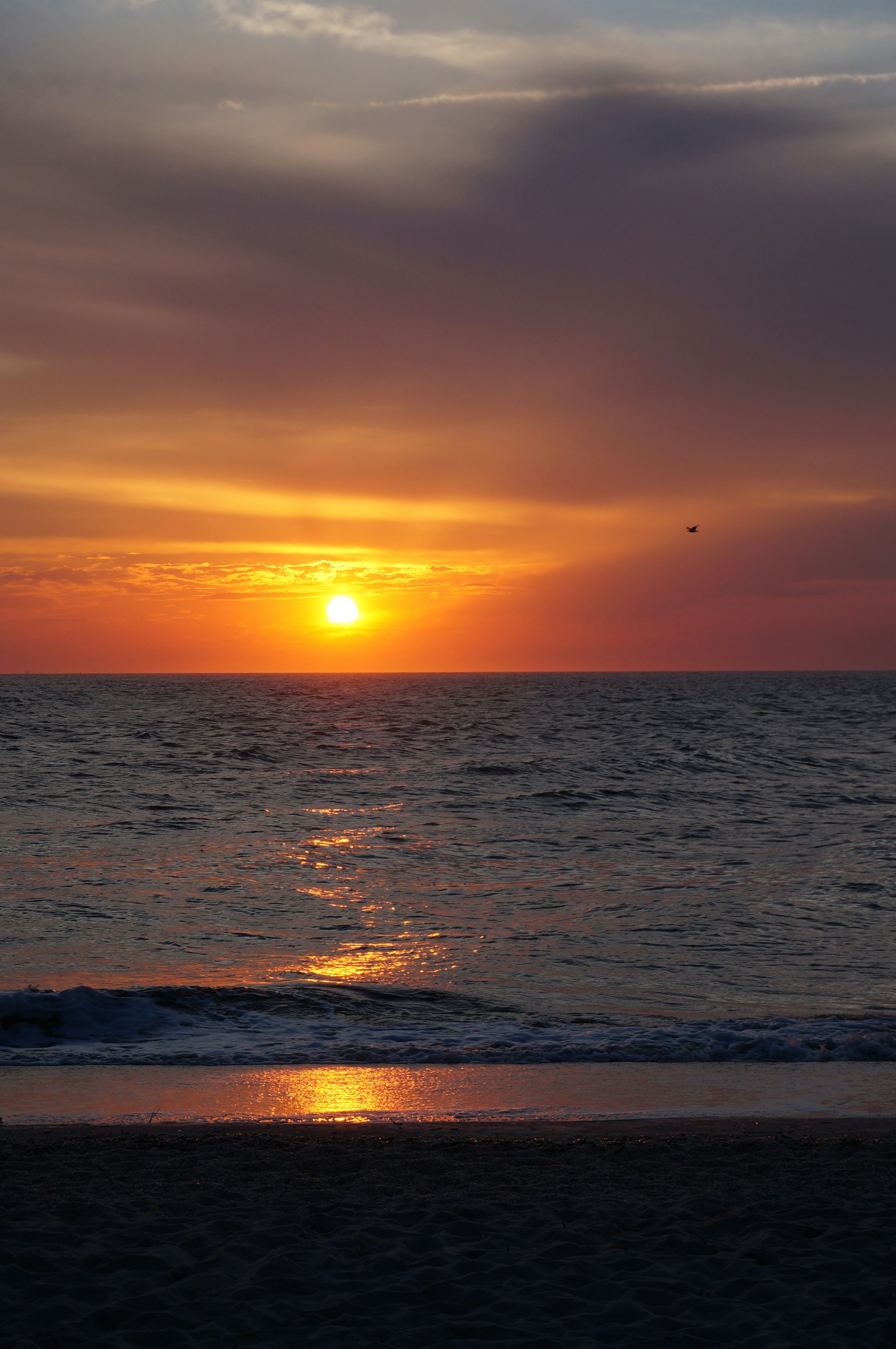 Sunset over a calm ocean with reflection